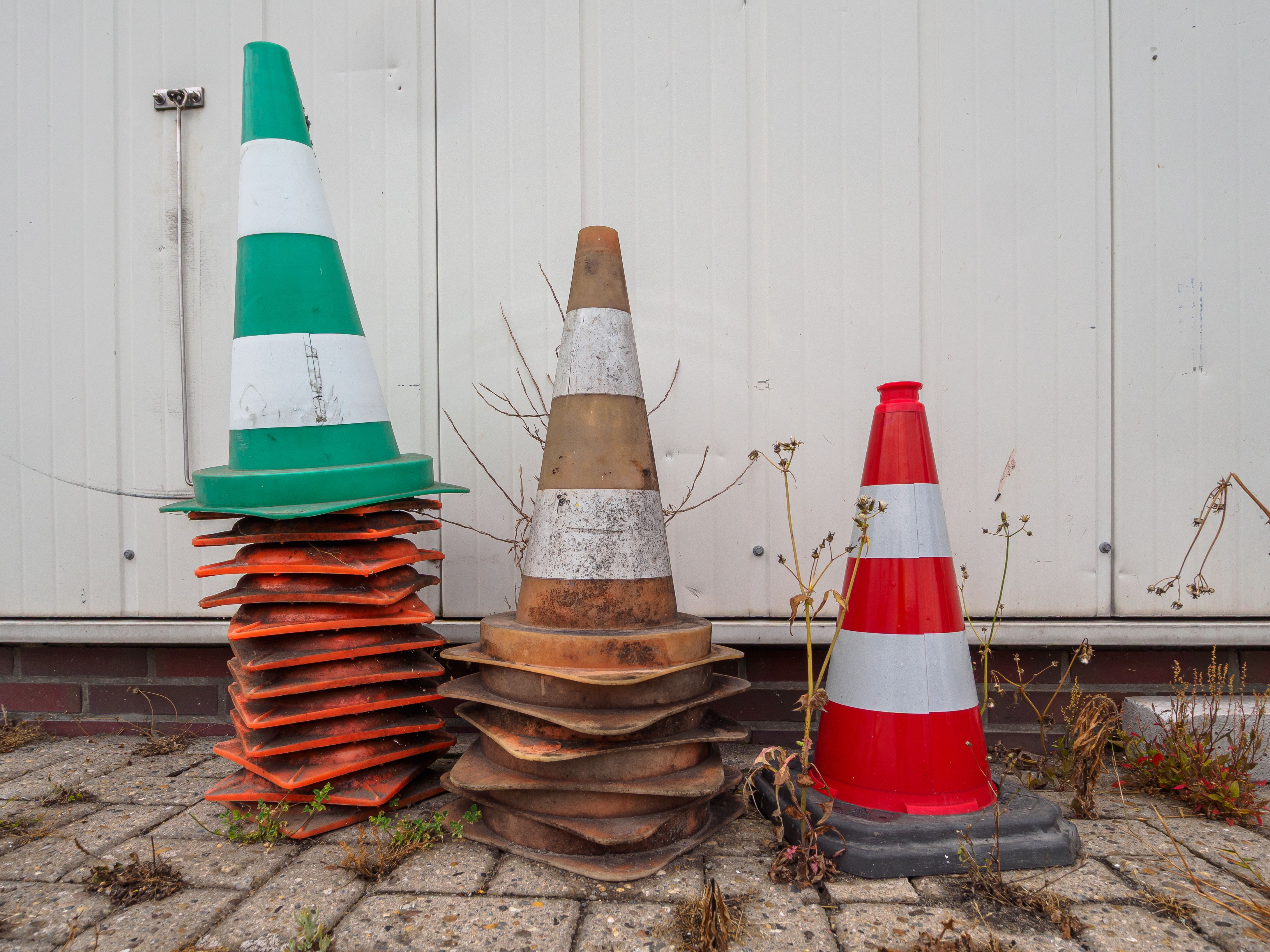 Colorful Traffic Cones Against White Wall · Free Stock Photo