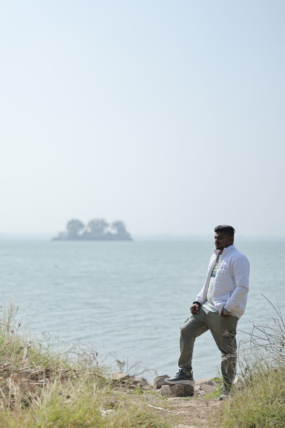 Man Standing by Tranquil Lakeside on a Sunny Day · Free Stock Photo