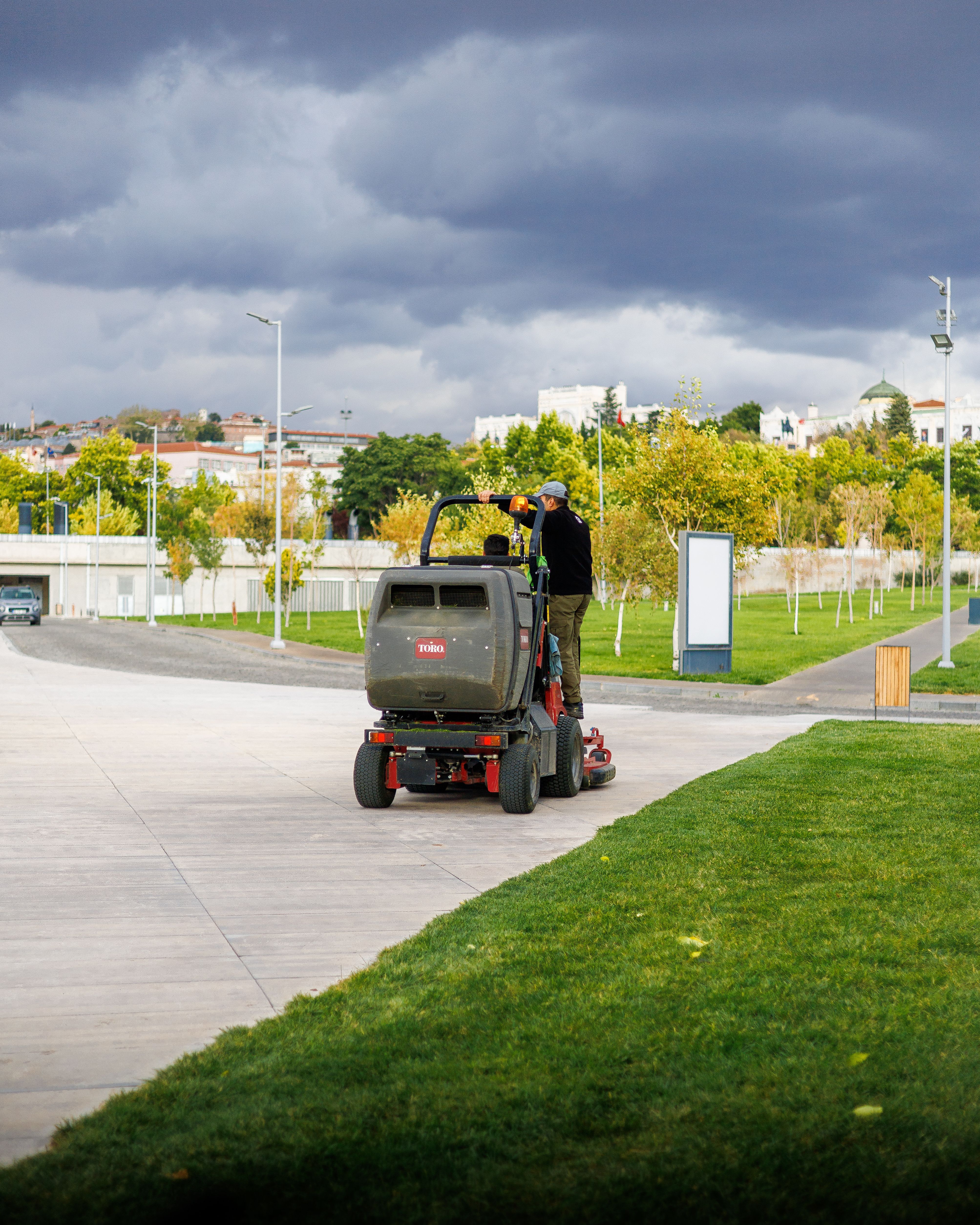 Park Maintenance Worker on Lawnmower in Urban Park · Free Stock Photo
