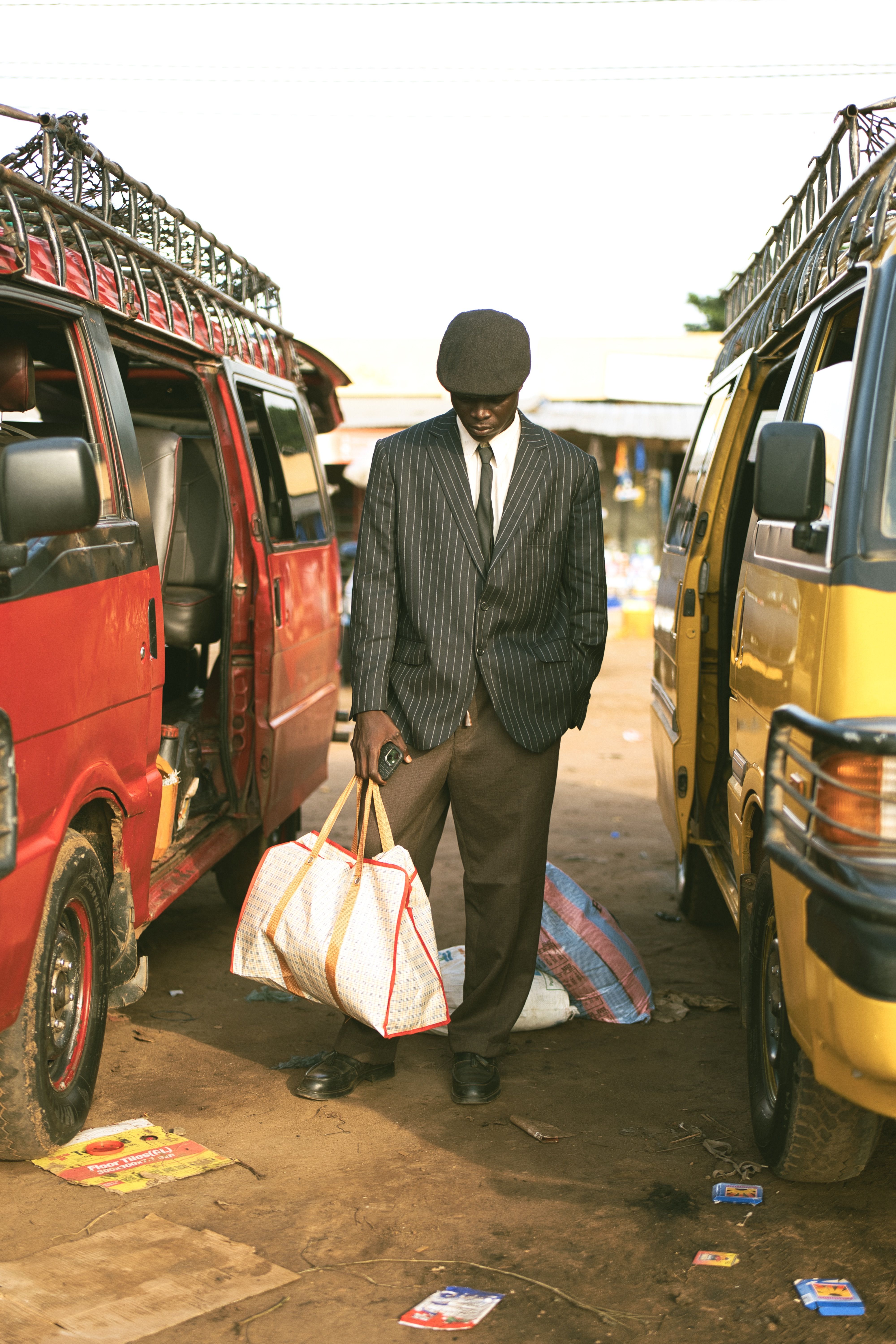 Man in Suit Standing Among Vans at Bus Station · Free Stock Photo