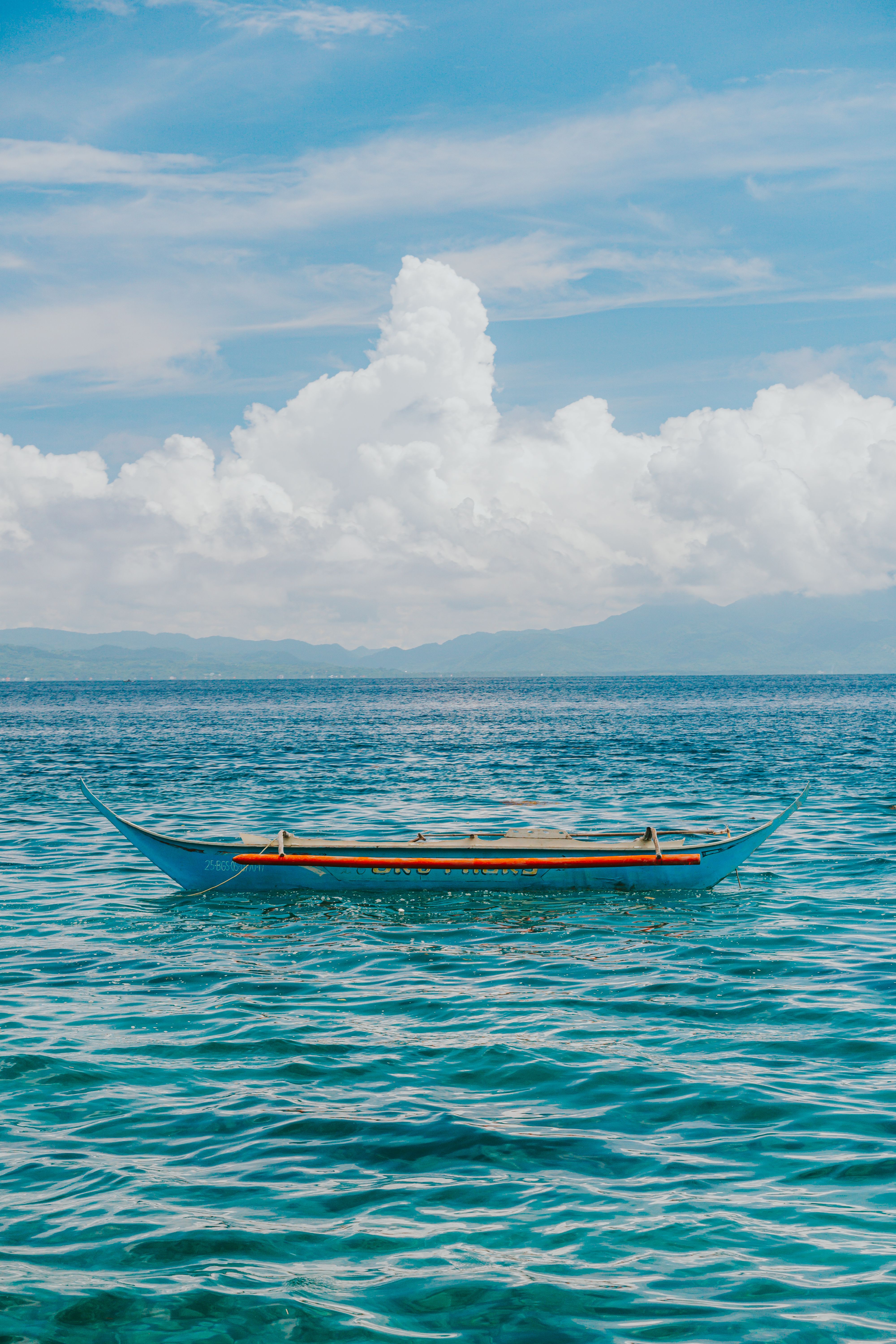 Serene Tropical Seascape with Traditional Boat · Free Stock Photo