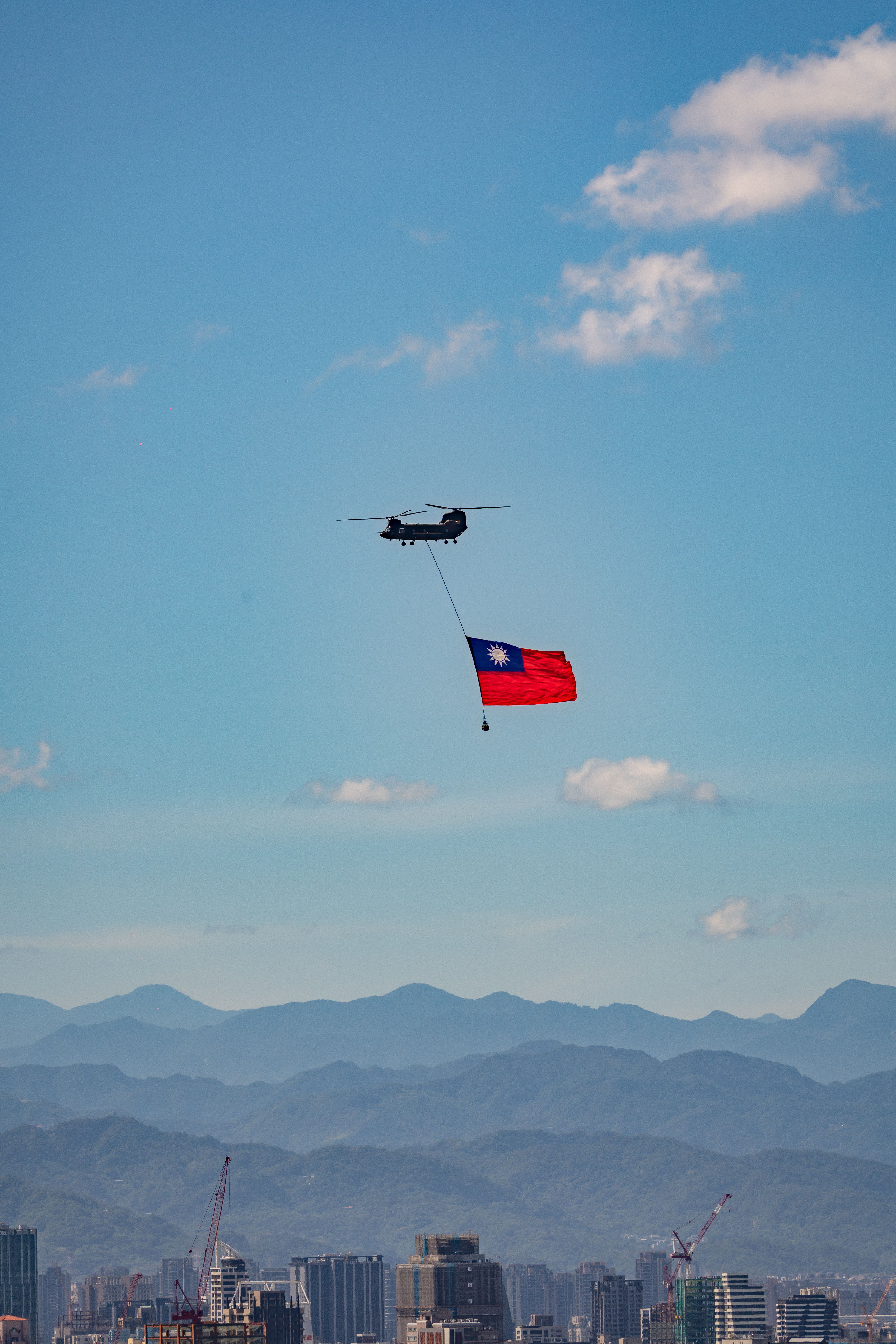 Helicopter Flying Over Taiwan Skyline Displaying Flag · Free Stock Photo