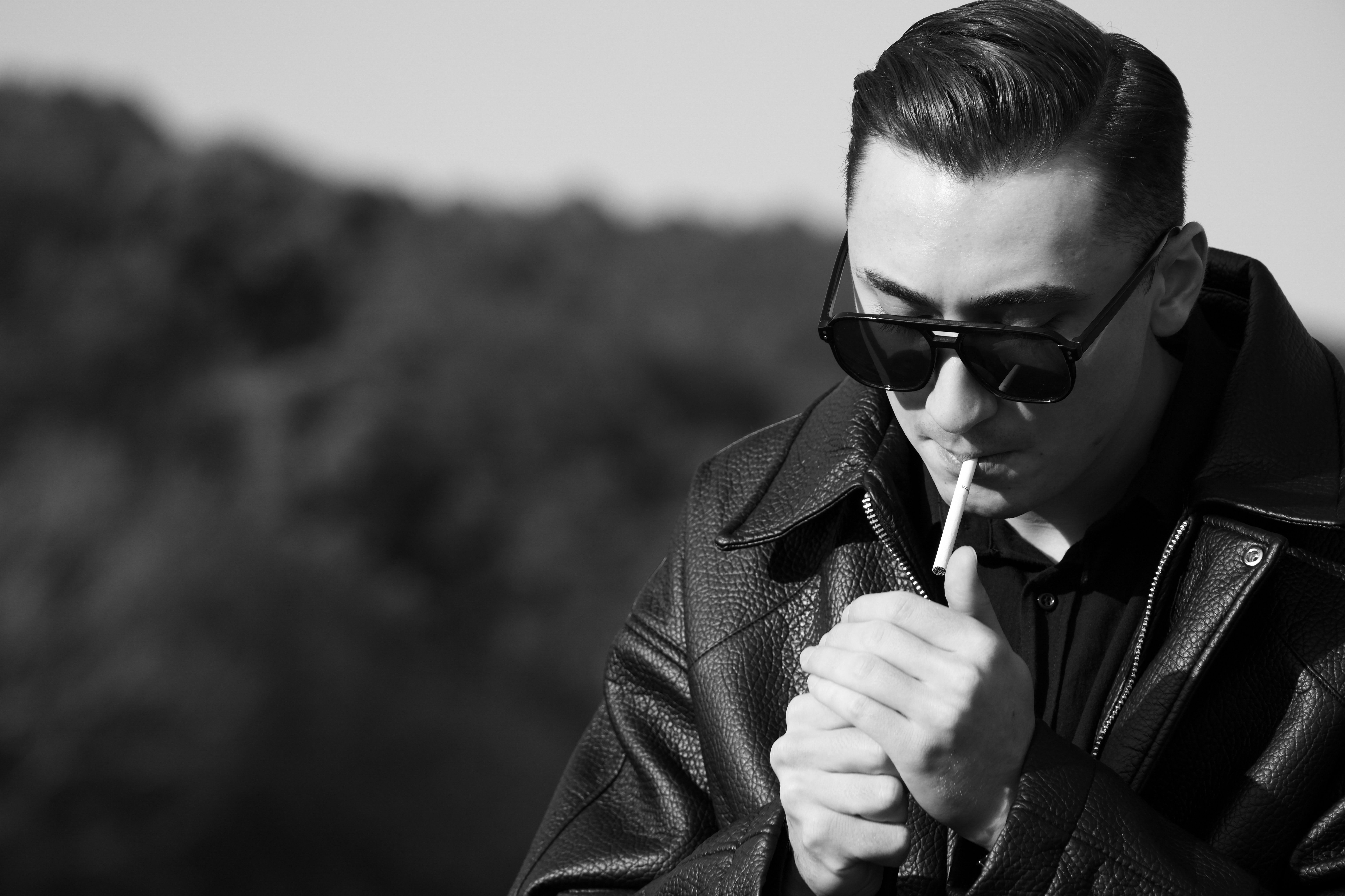 Stylish Man Lighting Cigarette in Black and White · Free Stock Photo