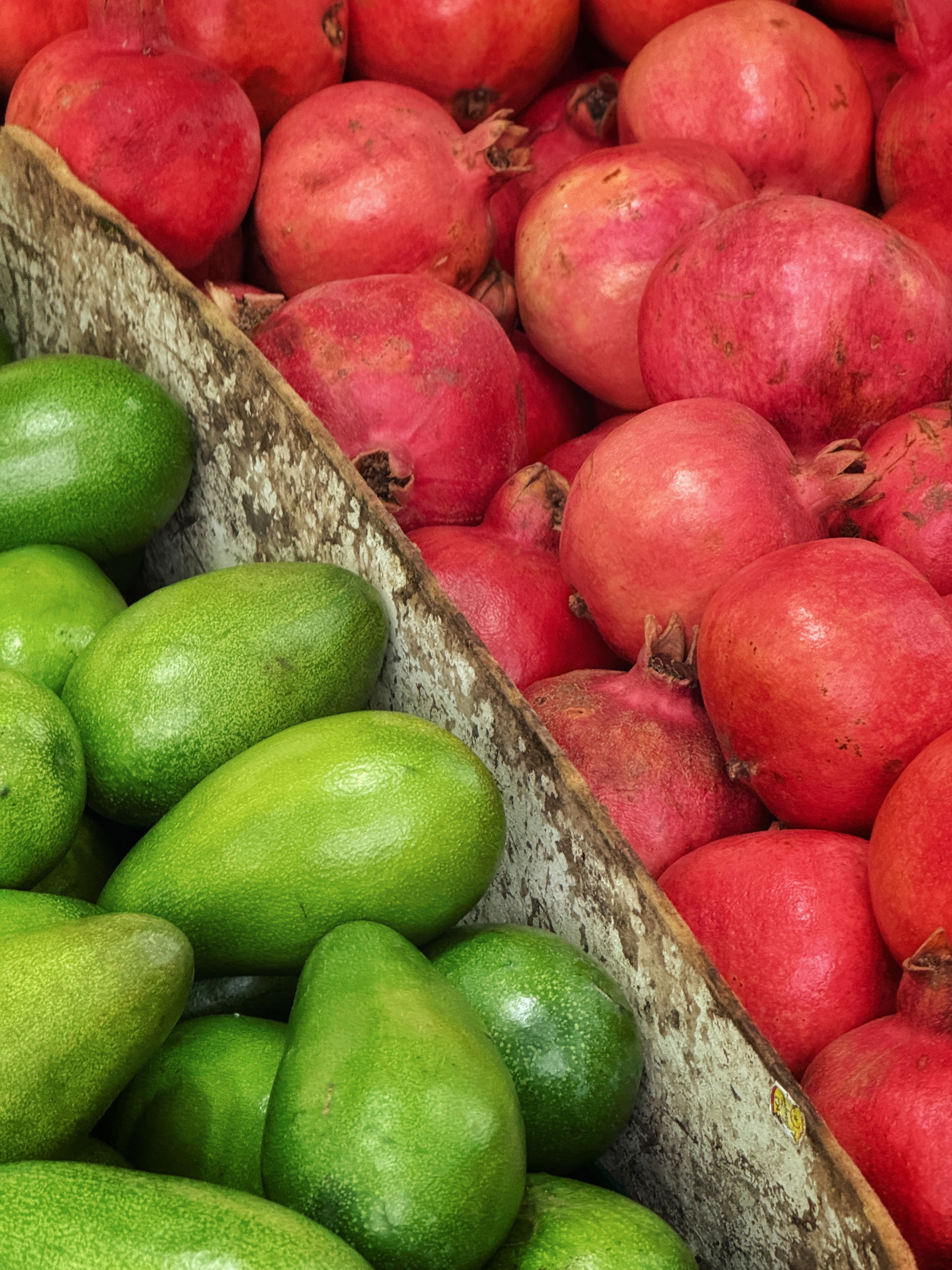 Fresh Avocados and Pomegranates Display at Market · Free Stock Photo