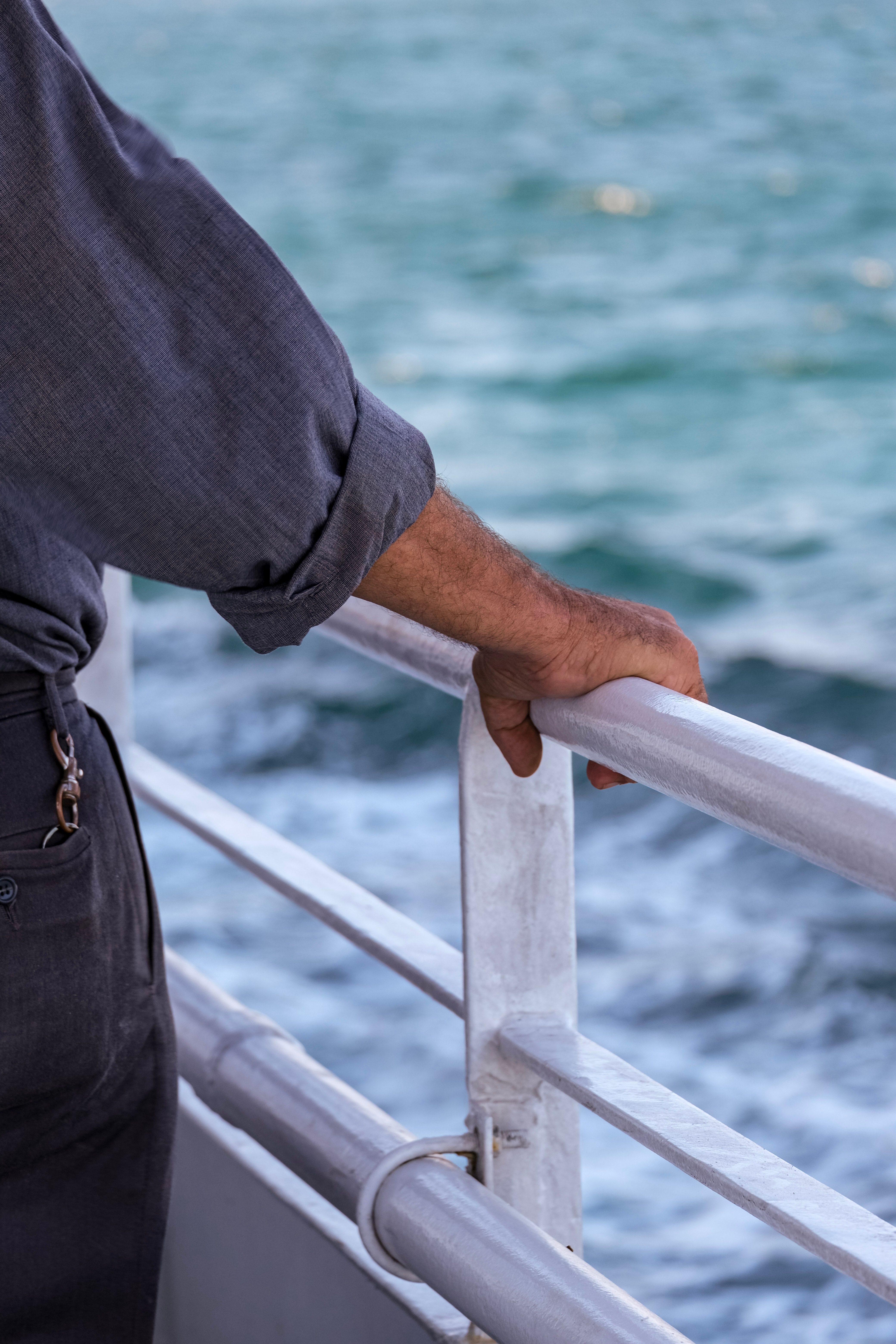 Close-Up of Person Leaning on Boat Rail with Ocean View · Free Stock Photo
