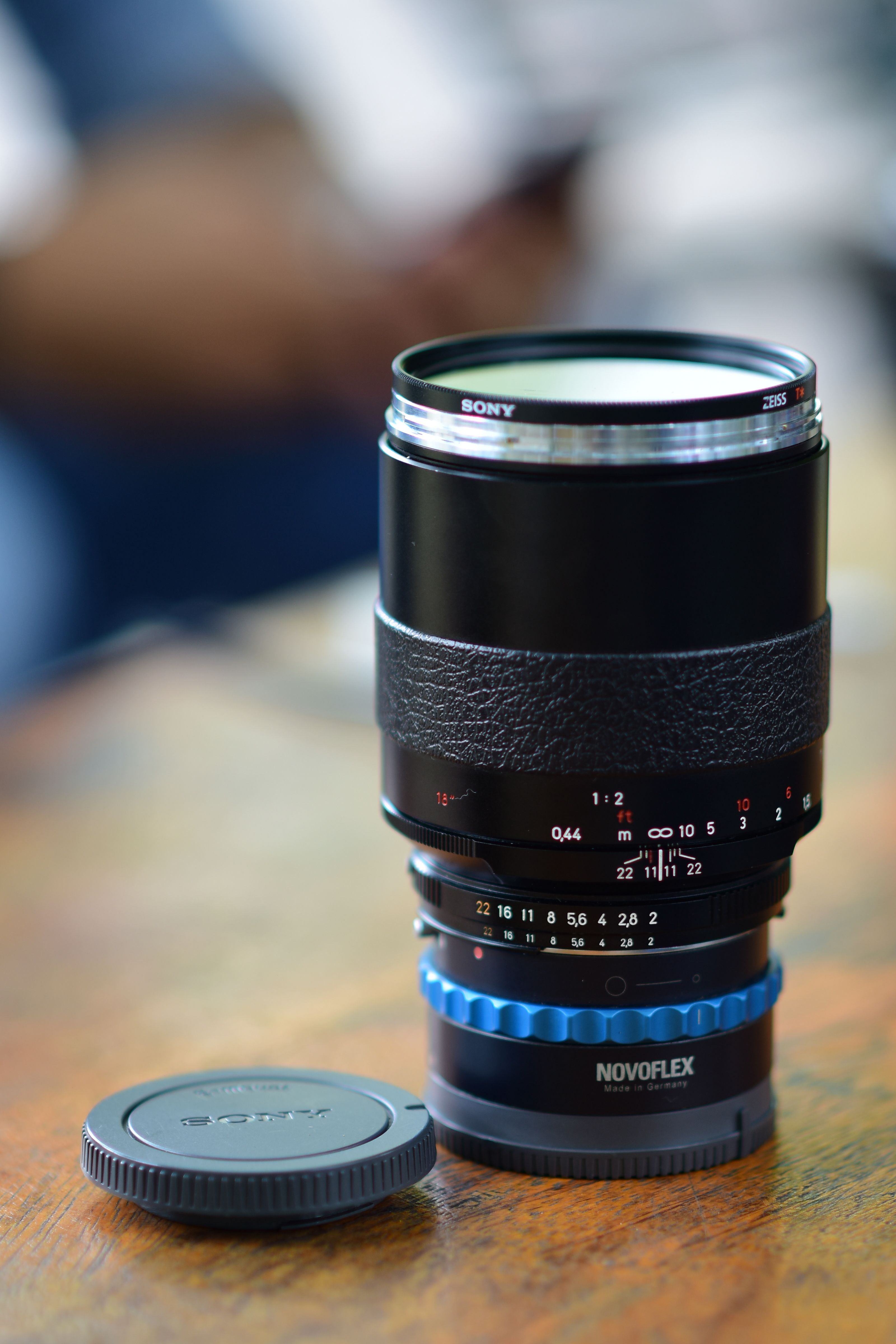Close-up of a professional camera lens on a table · Free Stock Photo