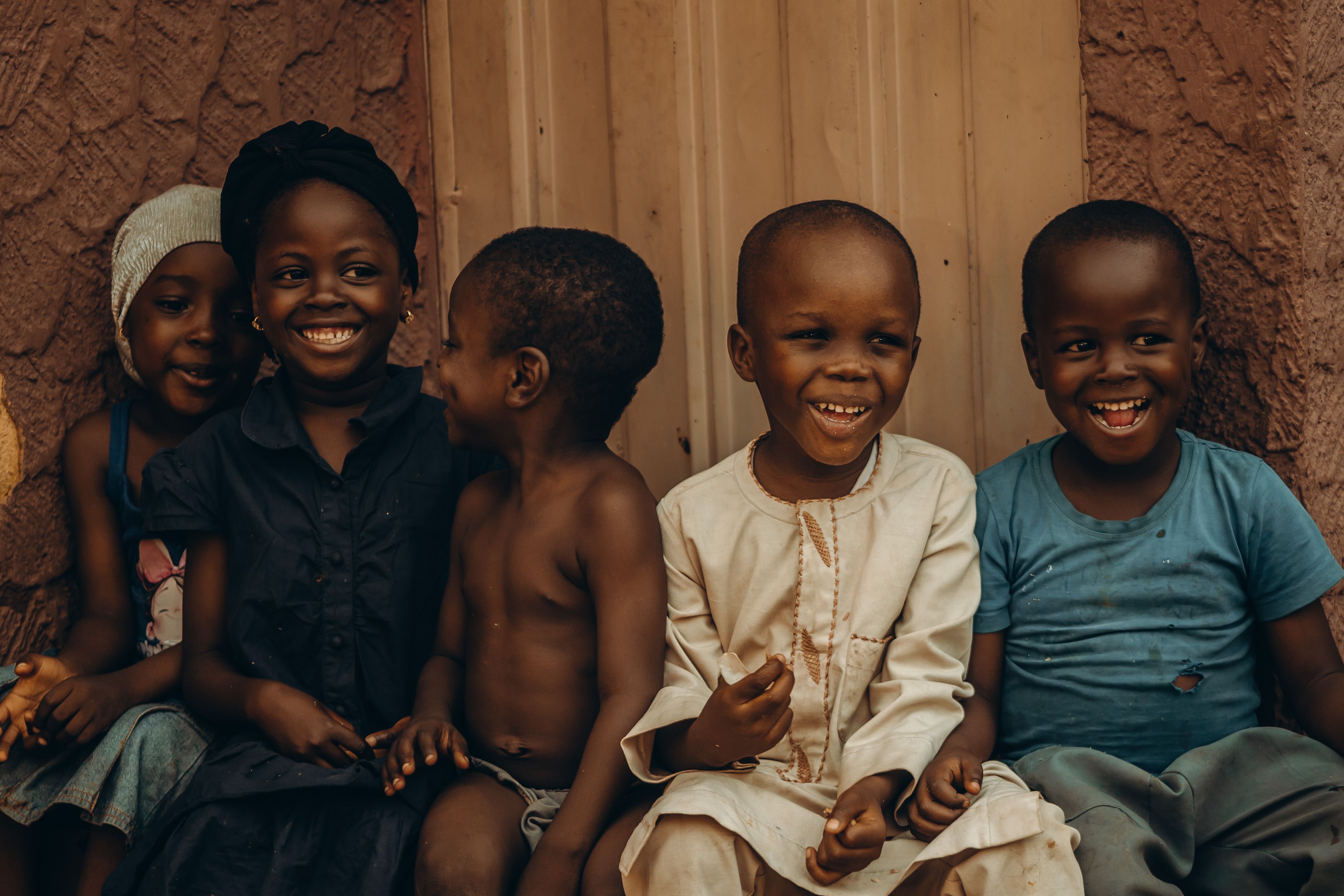 Smiling African Children Sitting Together Cheerfully · Free Stock Photo