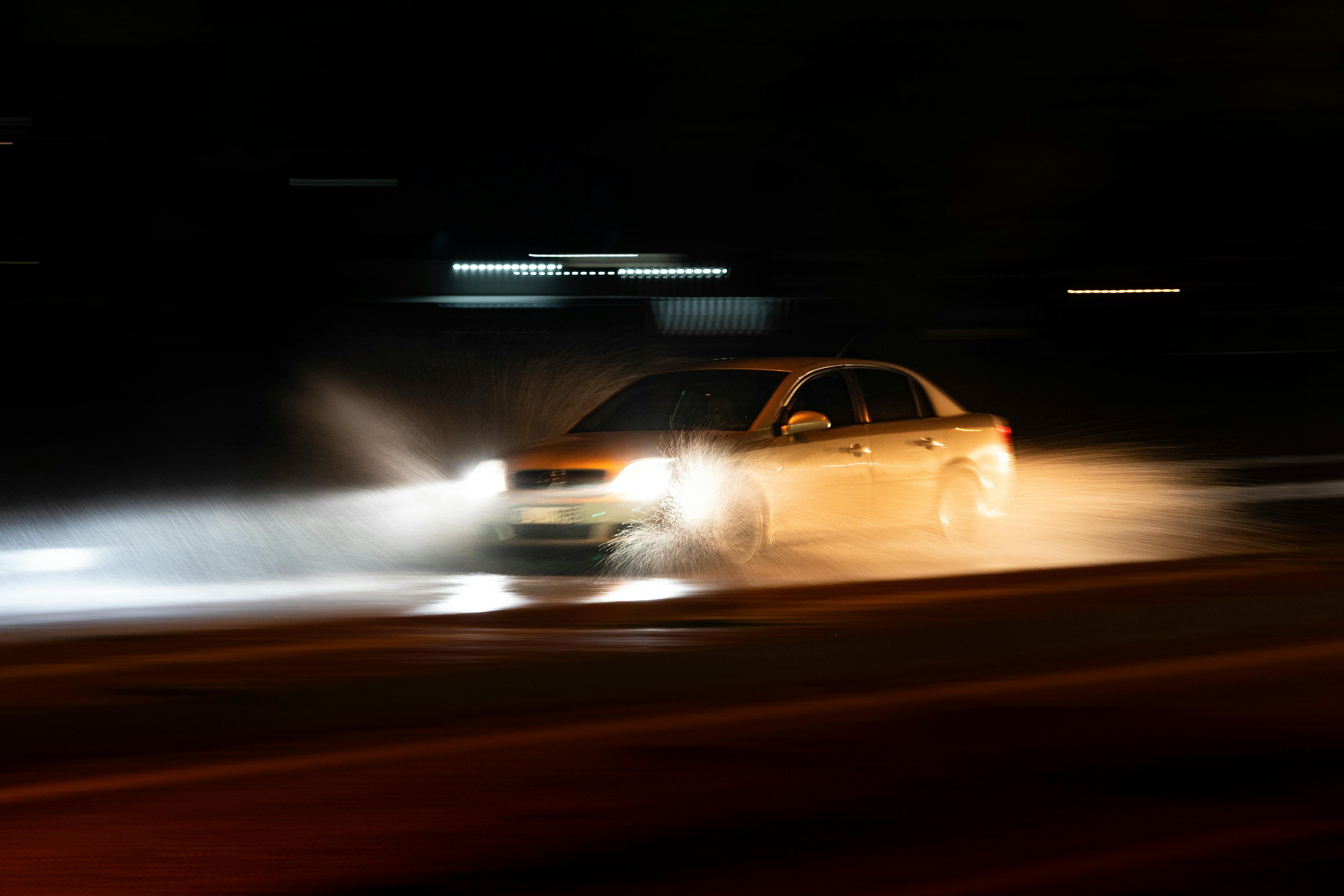 Dynamic Night Scene of Car Splashing Water · Free Stock Photo