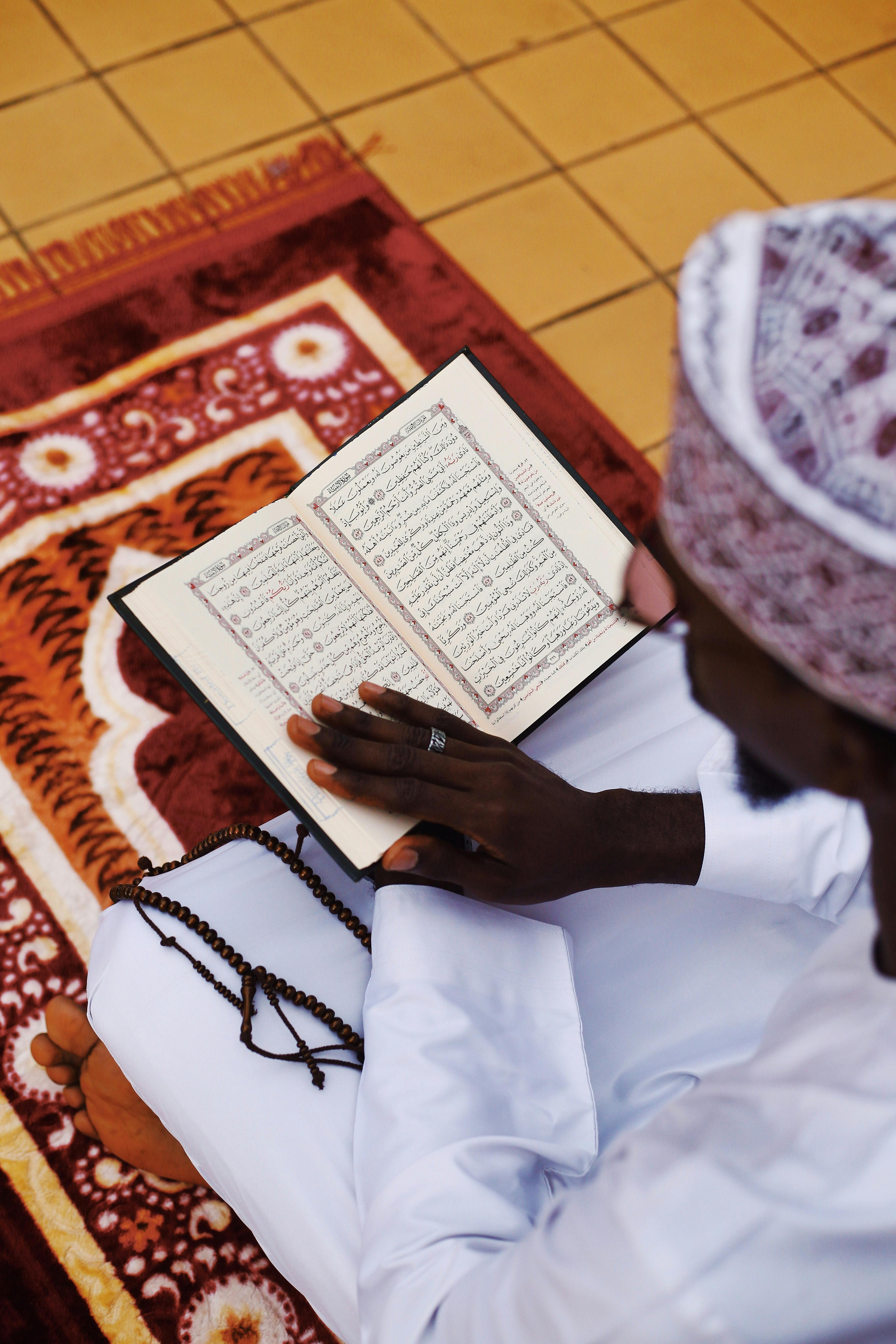 Man Reading Quran on Prayer Mat in Nigeria · Free Stock Photo