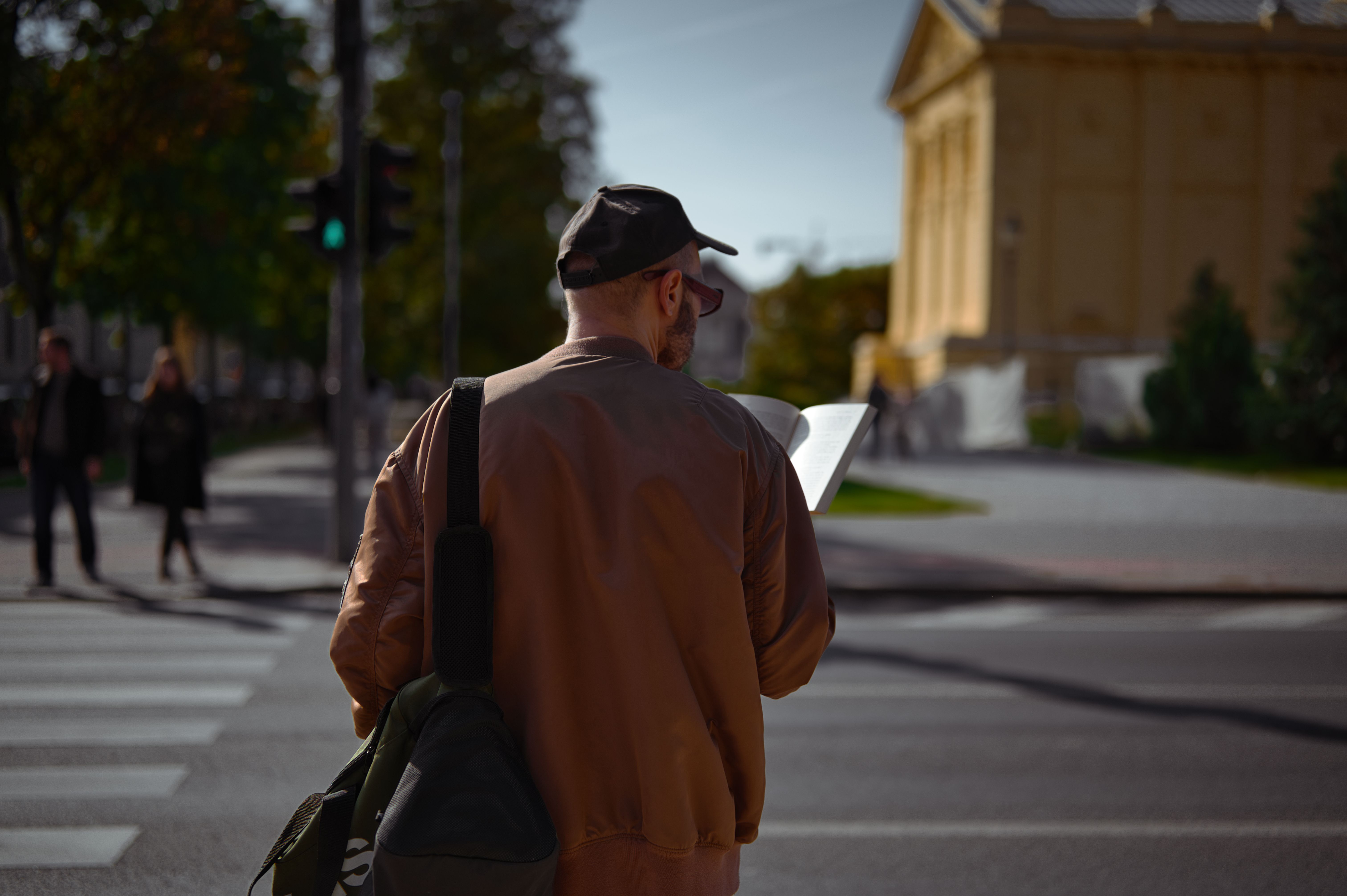 Man Reading Map at Crosswalk in Urban Setting · Free Stock Photo
