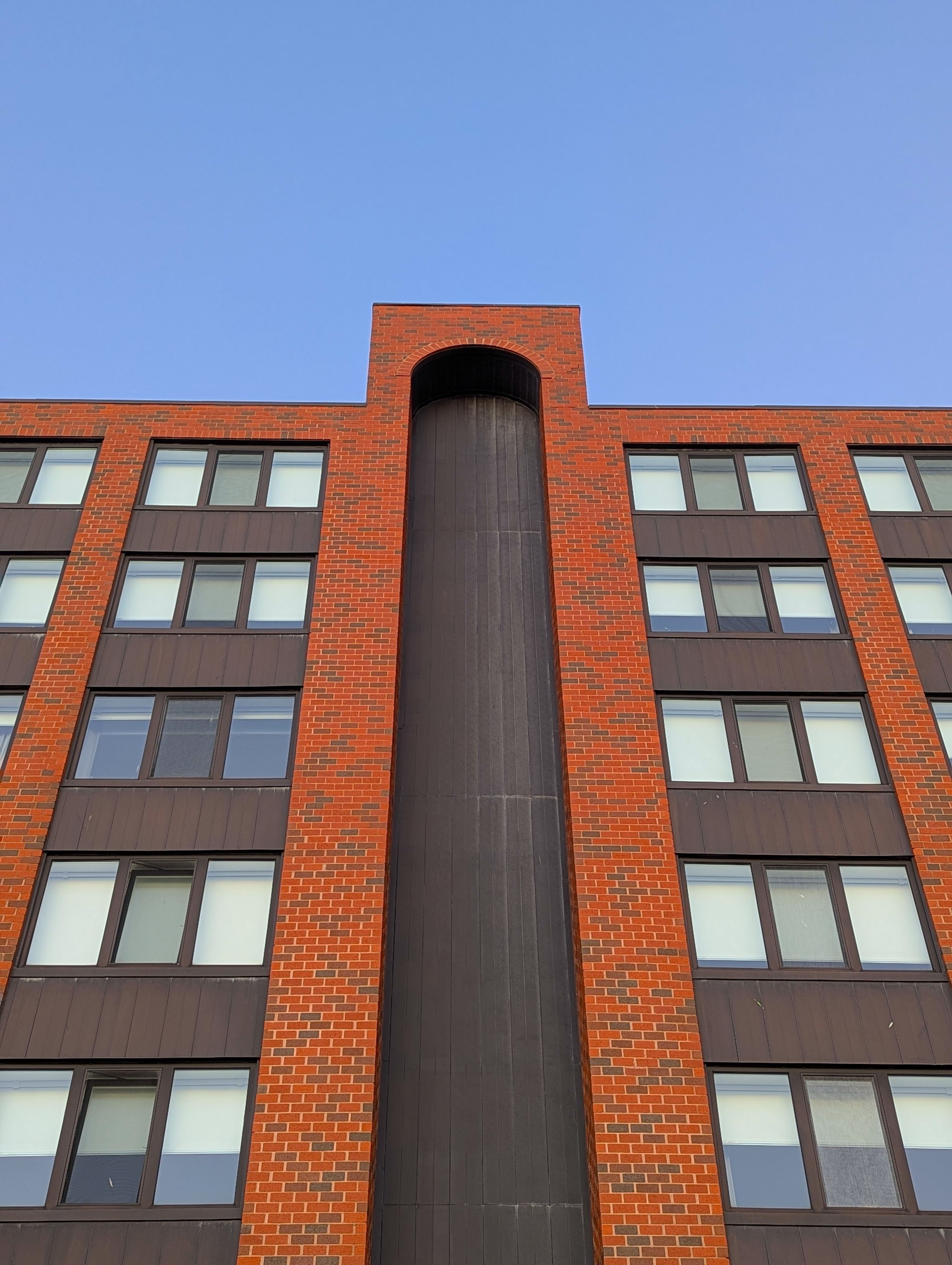 Modern Brick Building Against Clear Blue Sky · Free Stock Photo