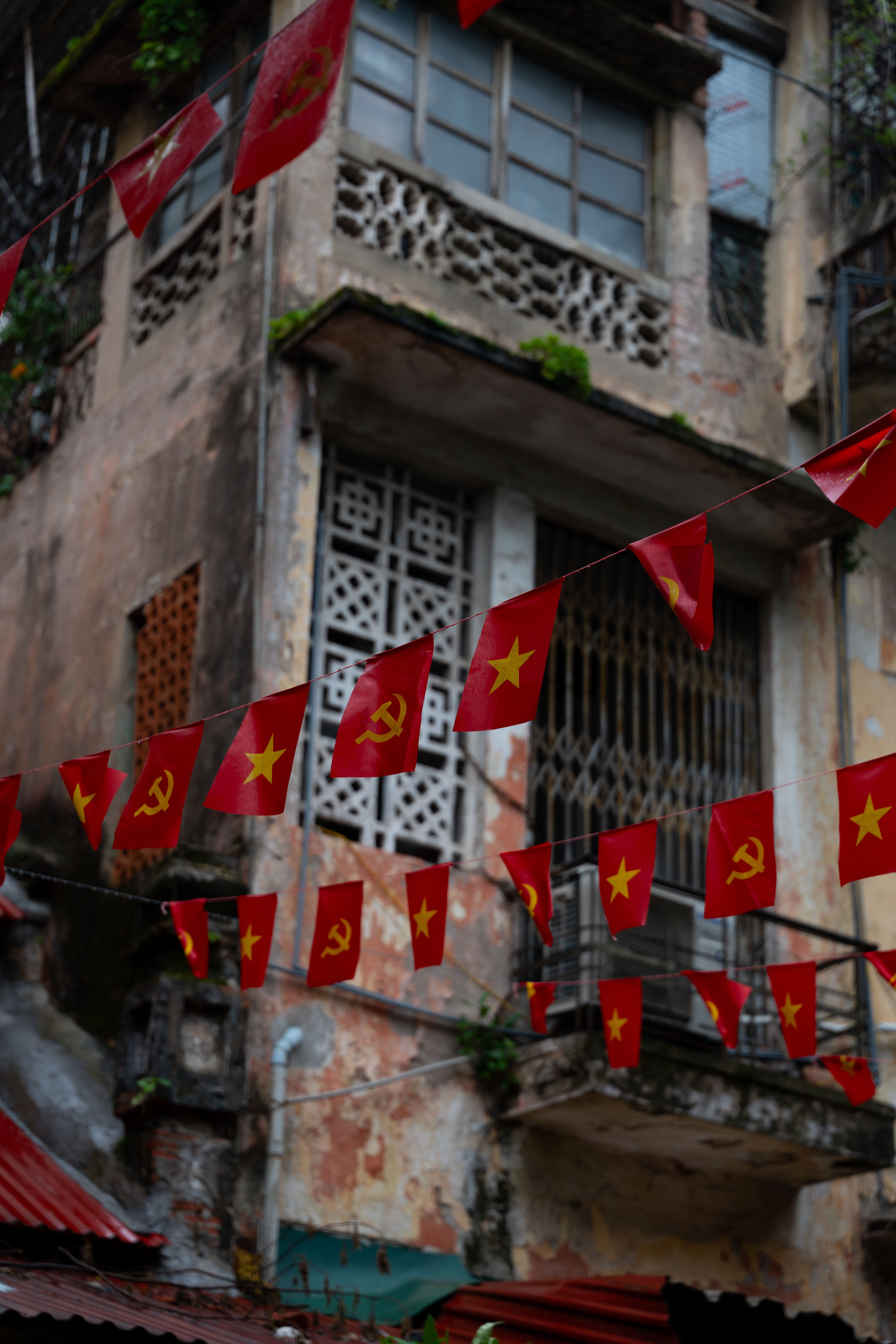 Old Building with Vietnamese Communist Flags in Hanoi · Free Stock Photo