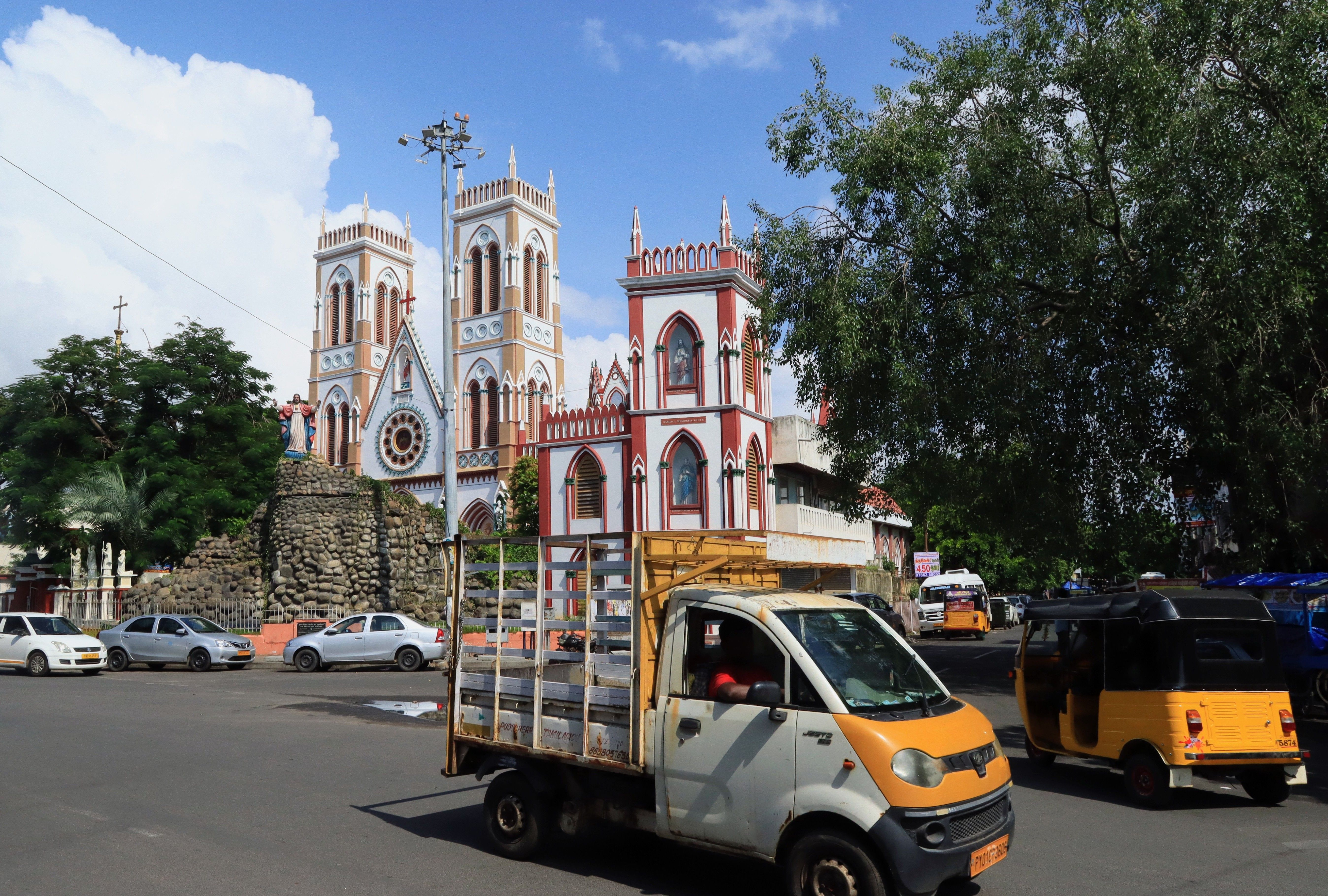 Vibrant Urban Scene with Historic Church and Vehicles · Free Stock Photo