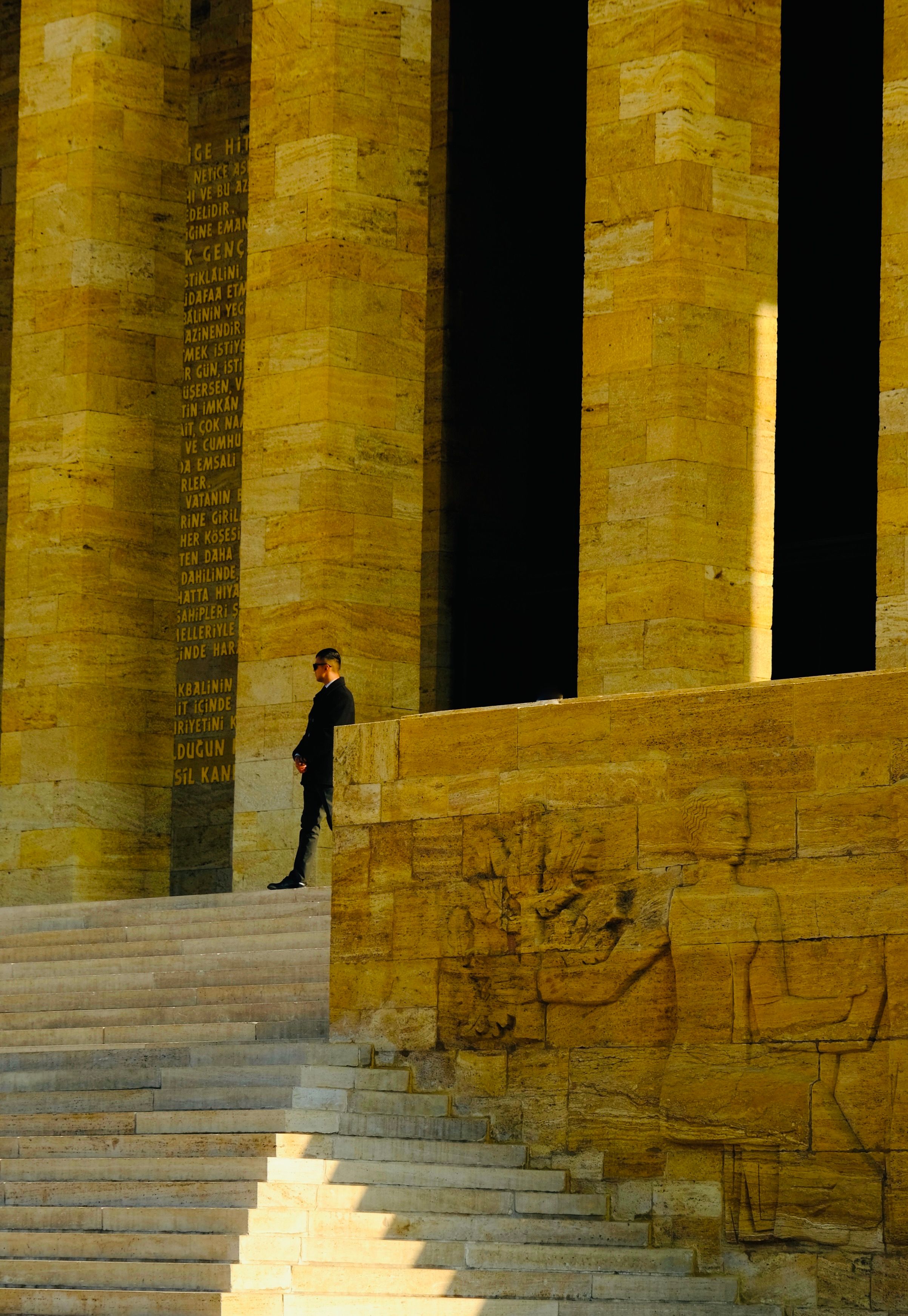Man Posing at Monument Steps with Dramatic Shadows · Free Stock Photo