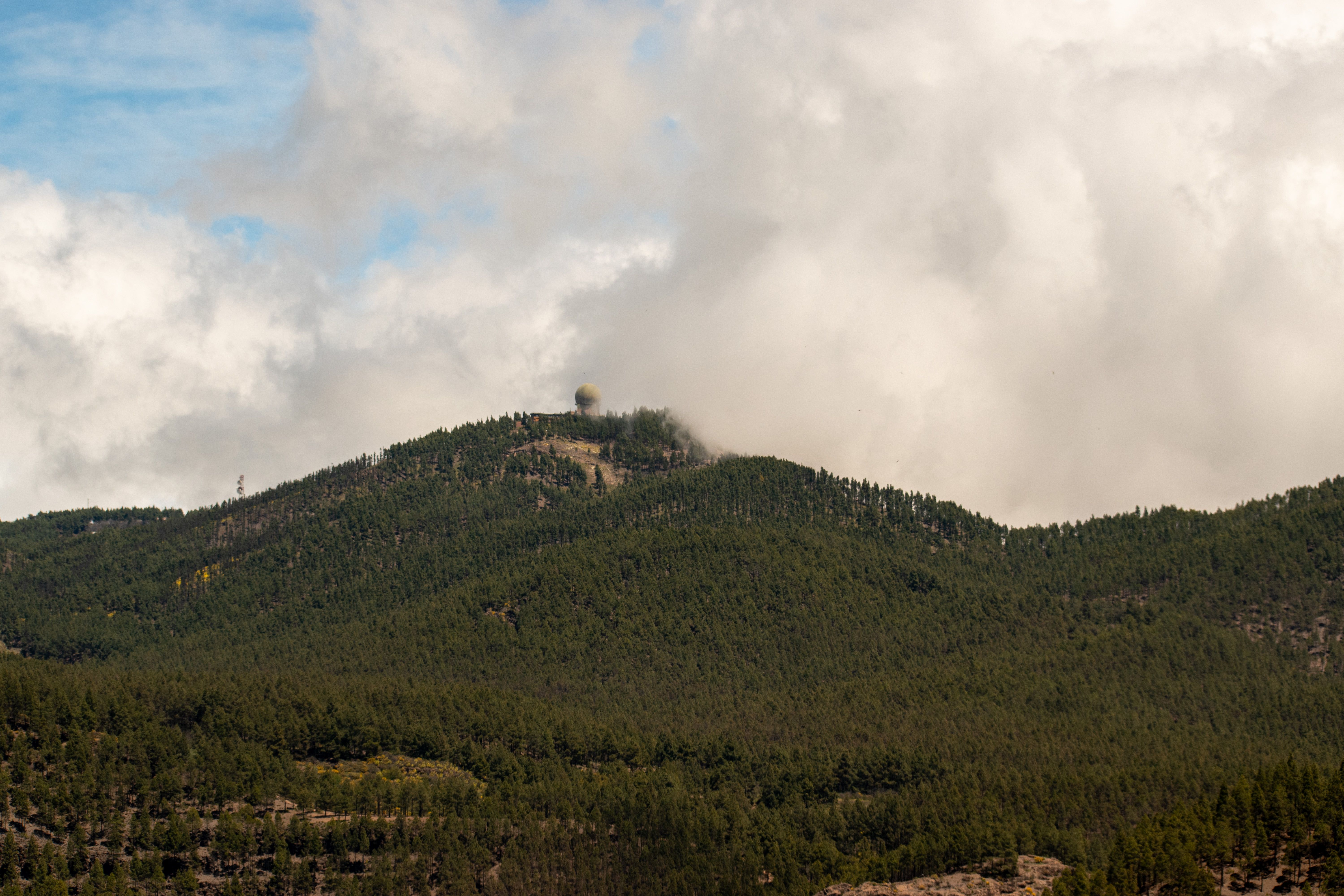 Dome Structure on Pine-Covered Mountain Peak · Free Stock Photo