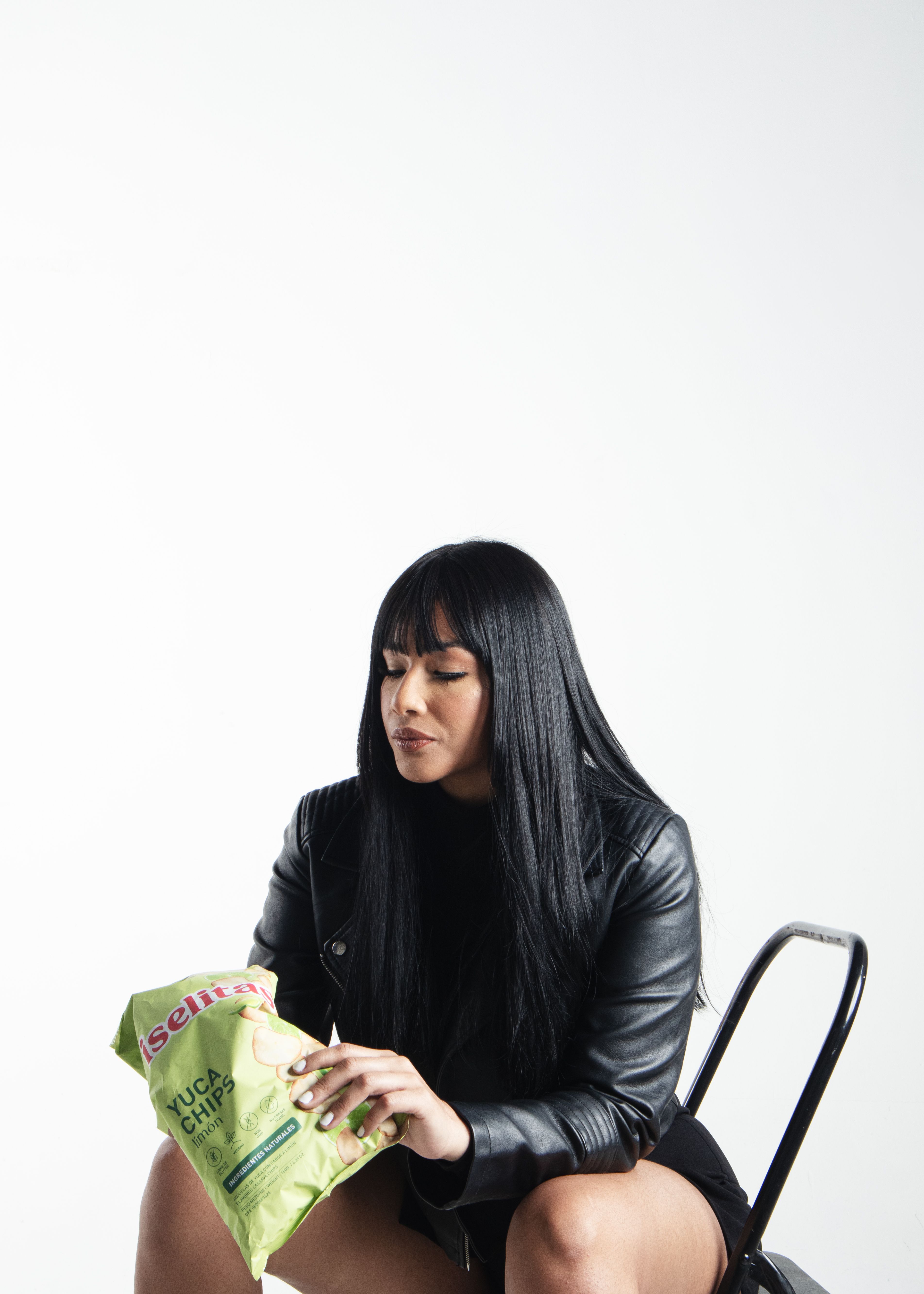 Woman Eating Yucca Chips in Modern Setting · Free Stock Photo