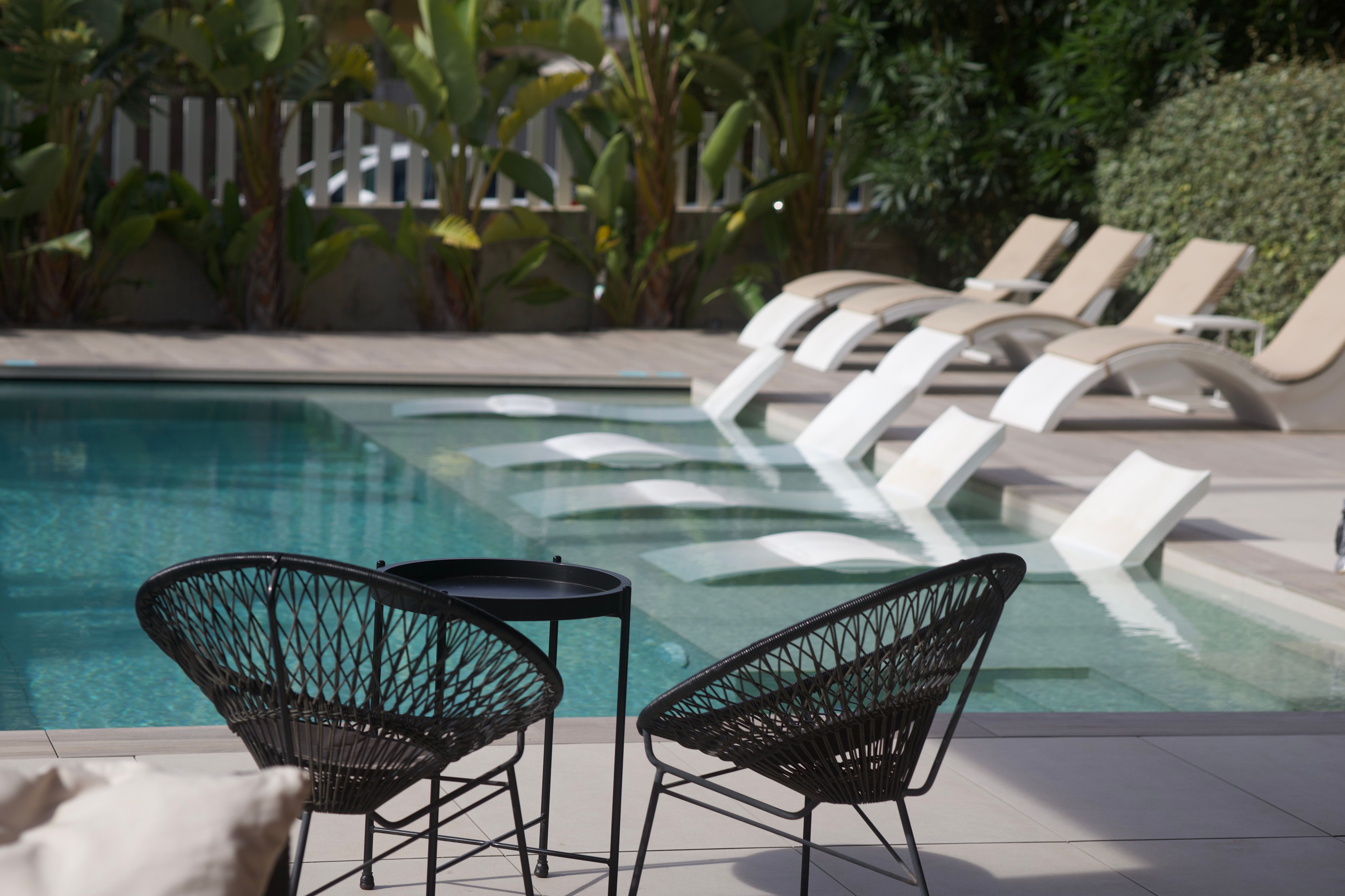 Modern Poolside Oasis with Stylish Seating Area · Free Stock Photo