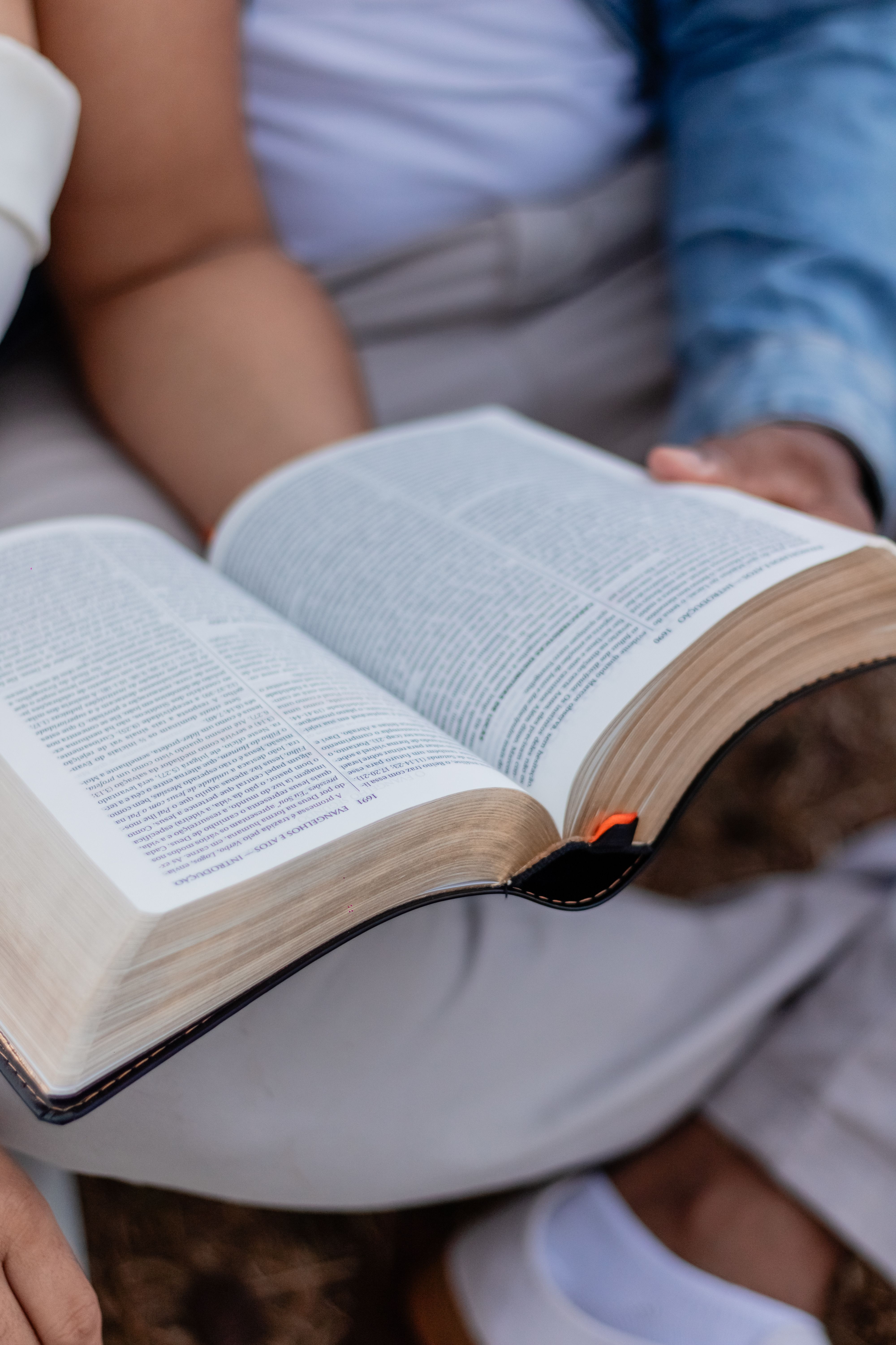 Close-up of Two People Reading a Book Together · Free Stock Photo