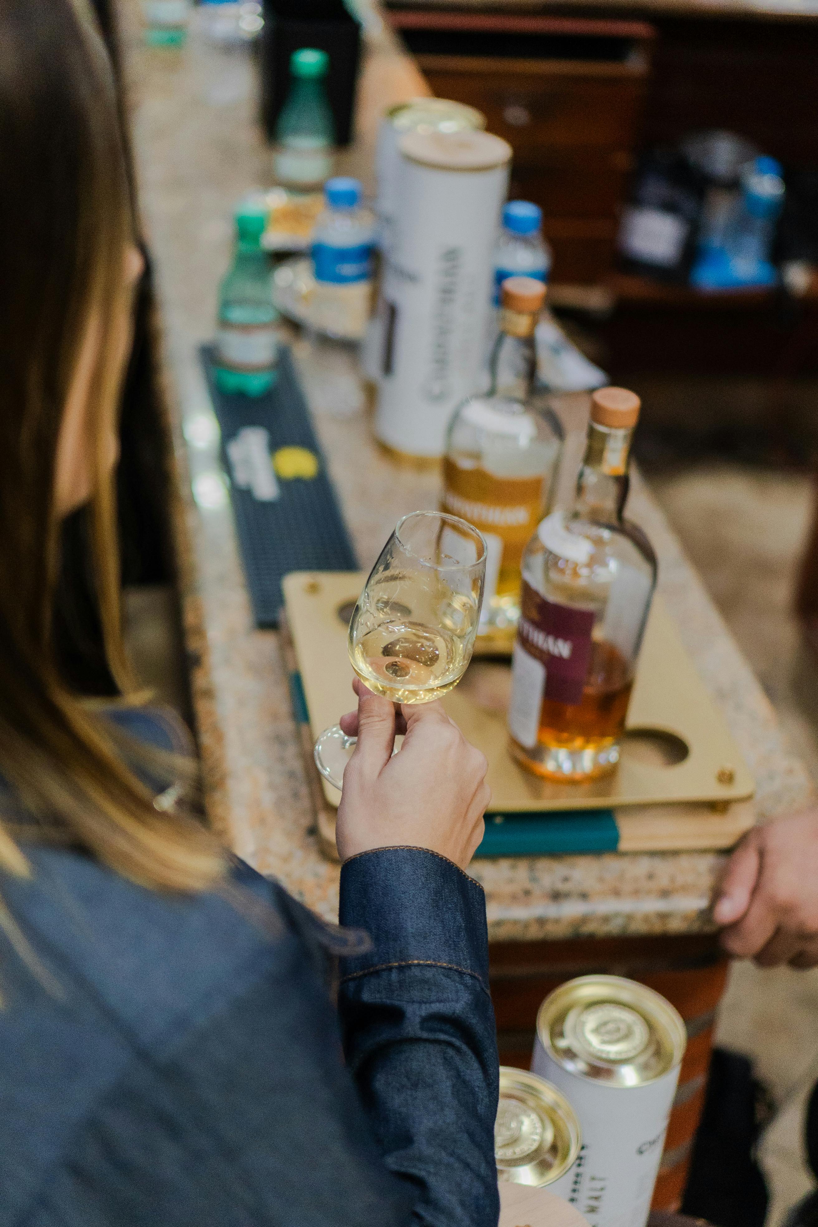 Person Sampling Whiskey at a Tasting Event · Free Stock Photo