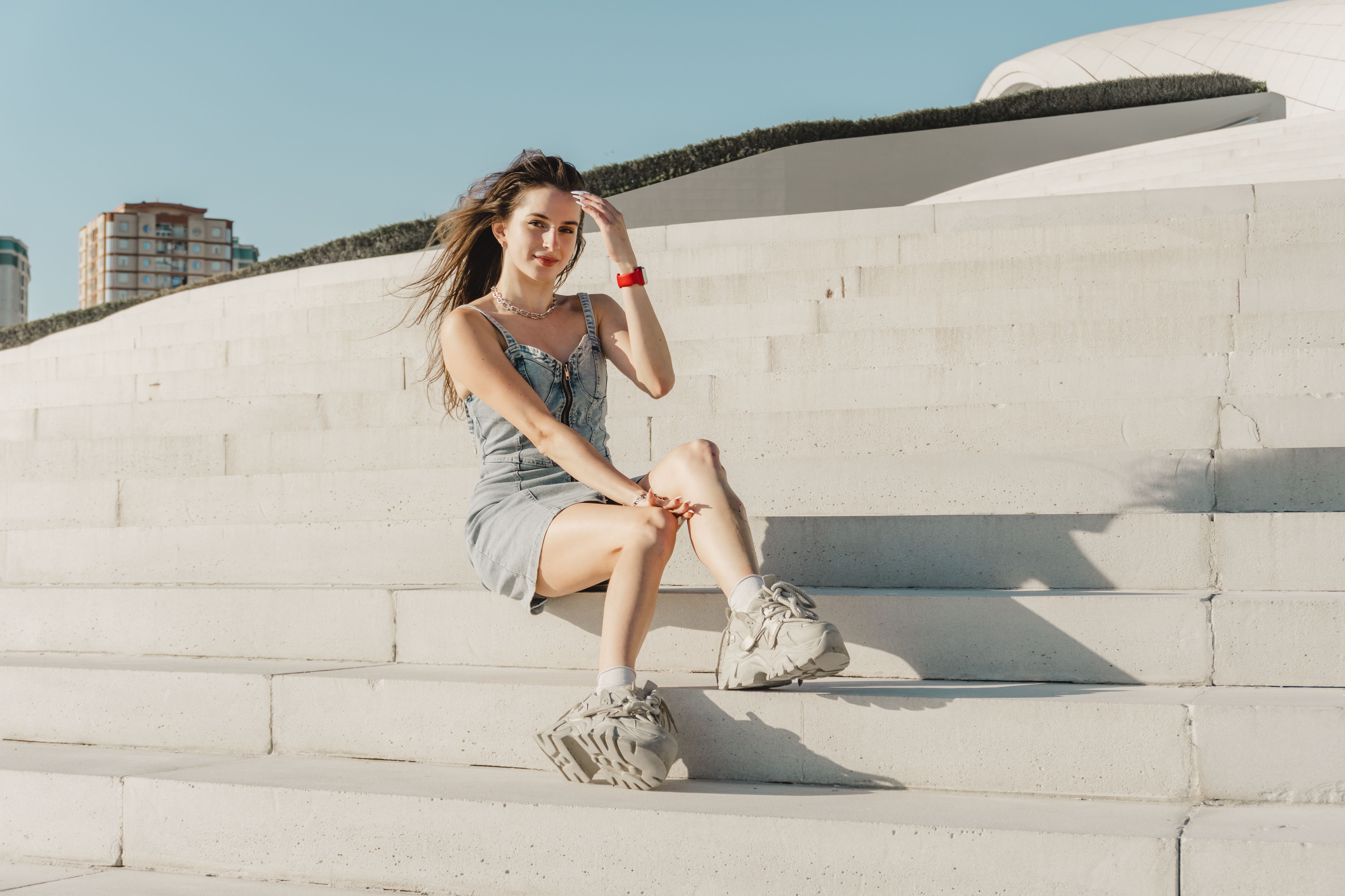 Trendy Young Woman Sitting on Modern Steps Outdoors · Free Stock Photo