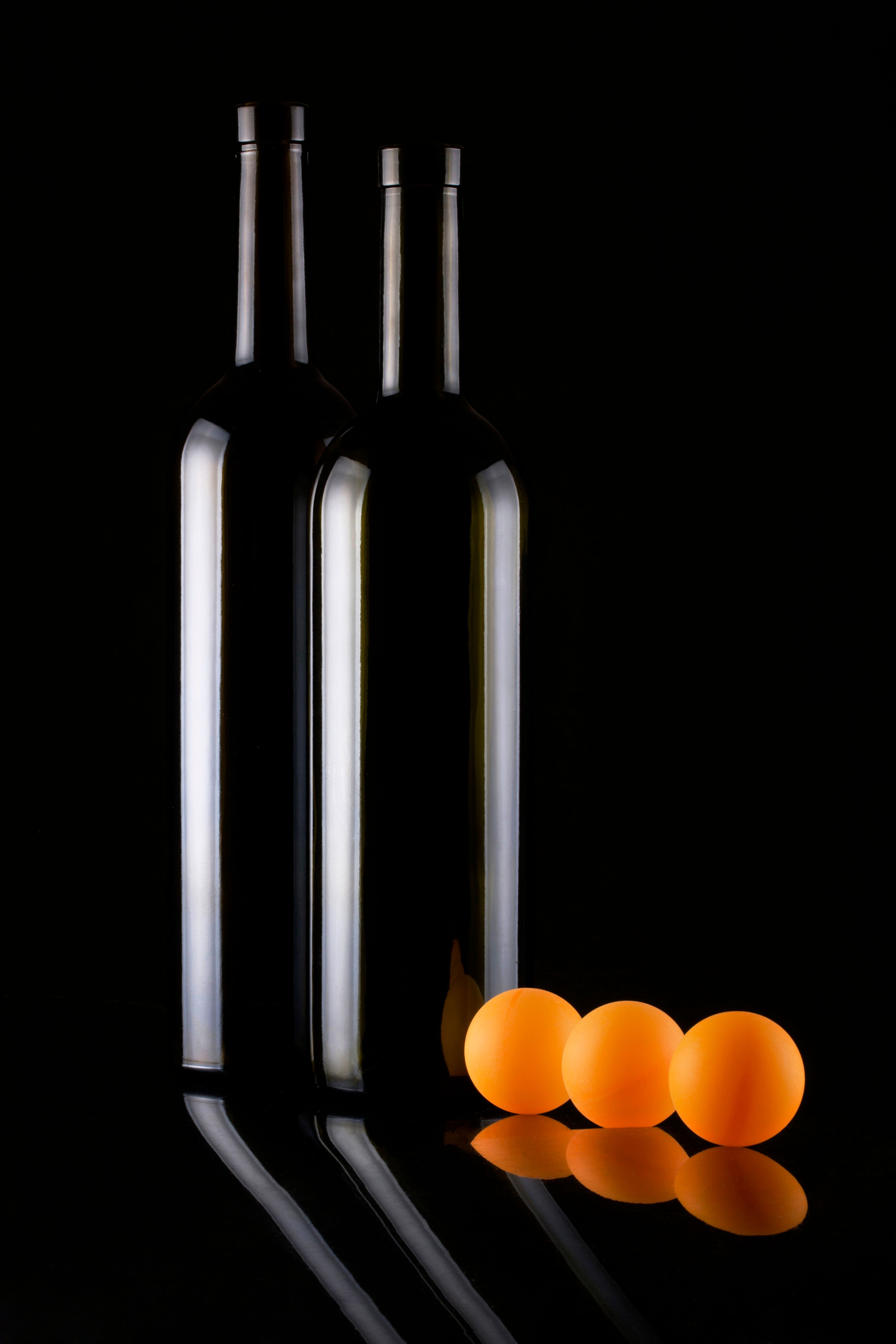 Elegant Still Life of Bottles and Balls on Black · Free Stock Photo
