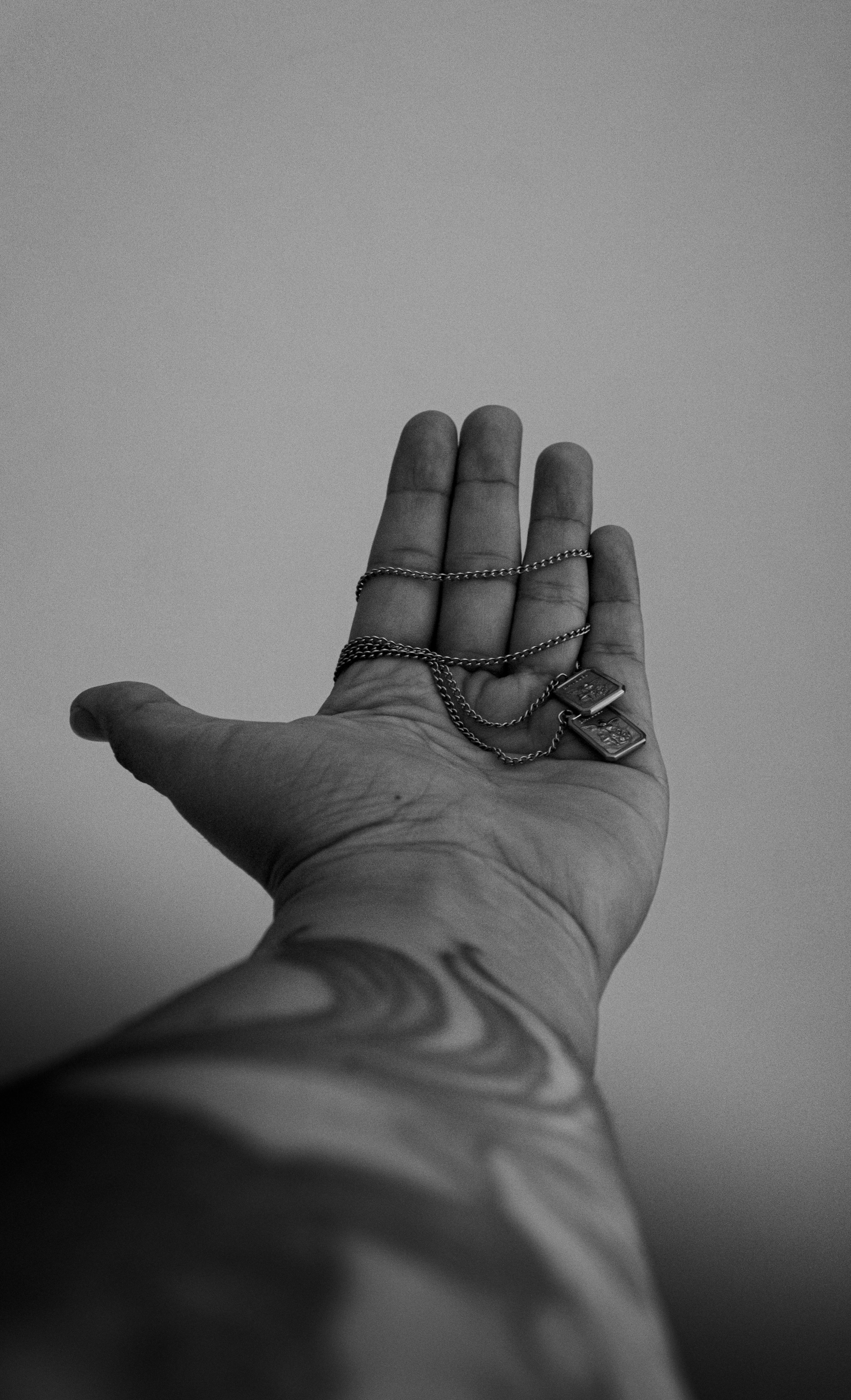 Grayscale Photo of Person's Hand Reaching For the Sky · Free Stock Photo