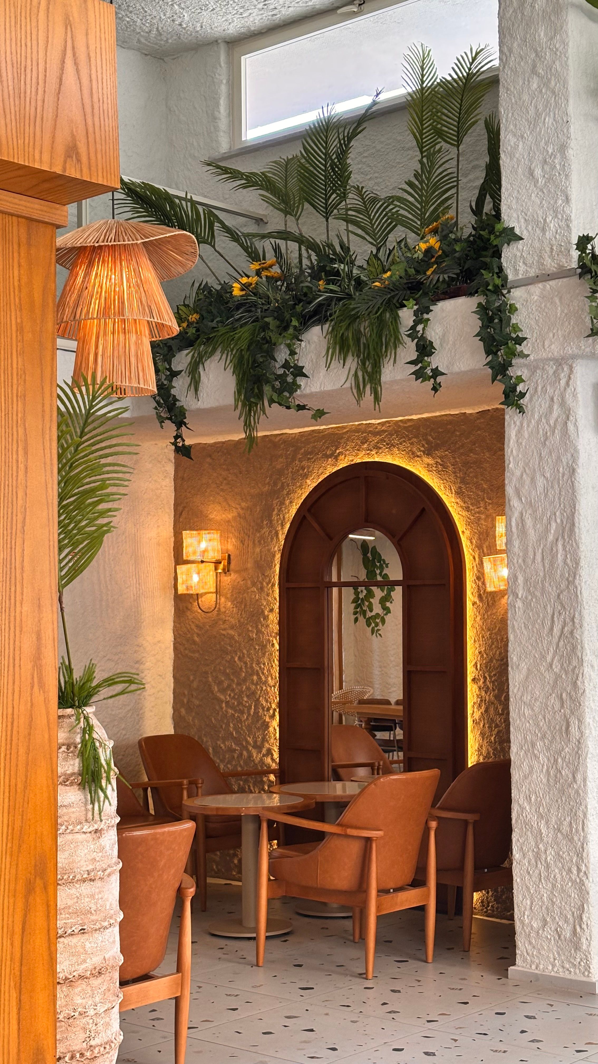 Cozy Mediterranean-style Café Interior with Plants · Free Stock Photo