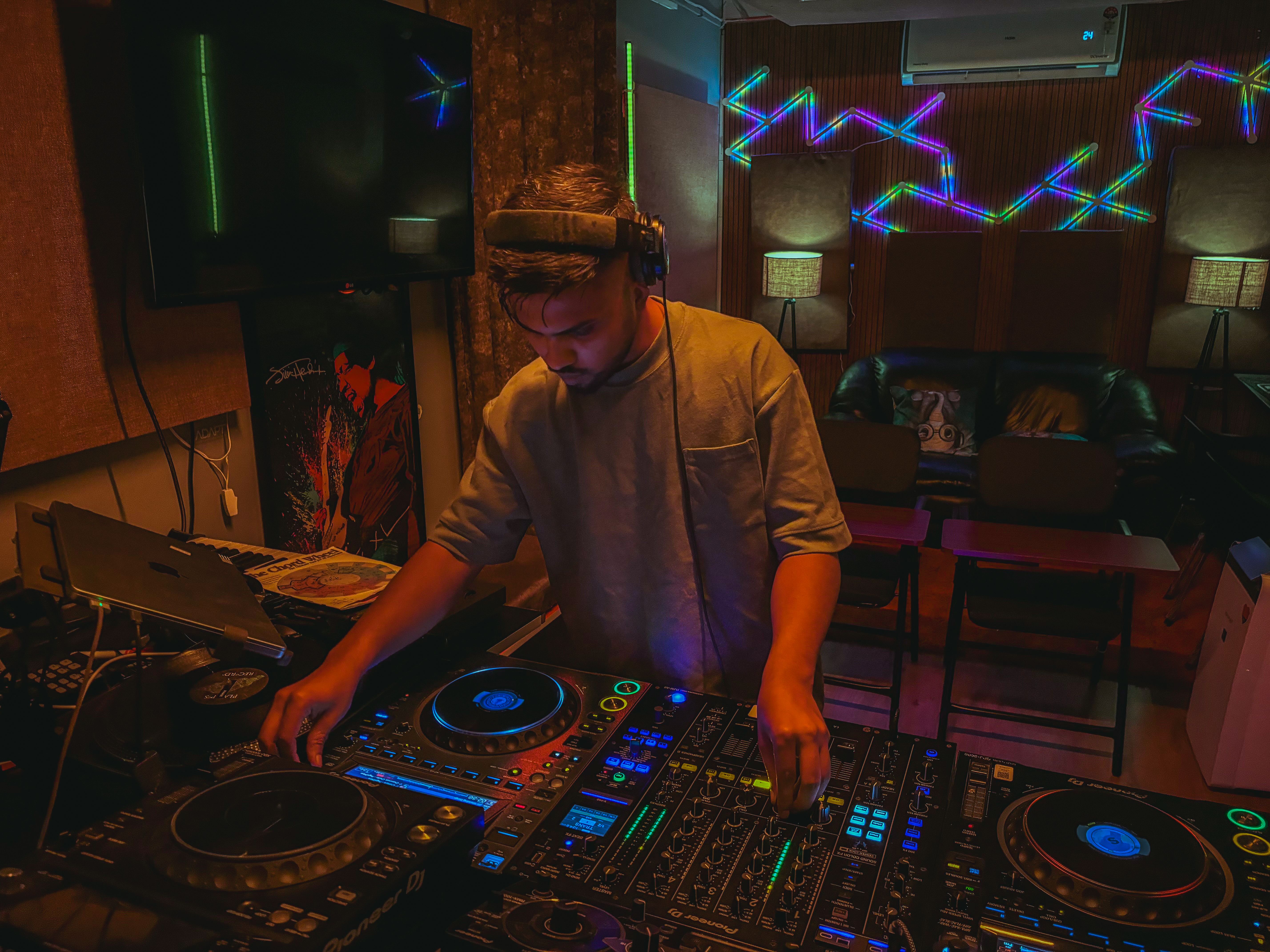 DJ Mixing Tracks in Vibrant Studio Environment · Free Stock Photo