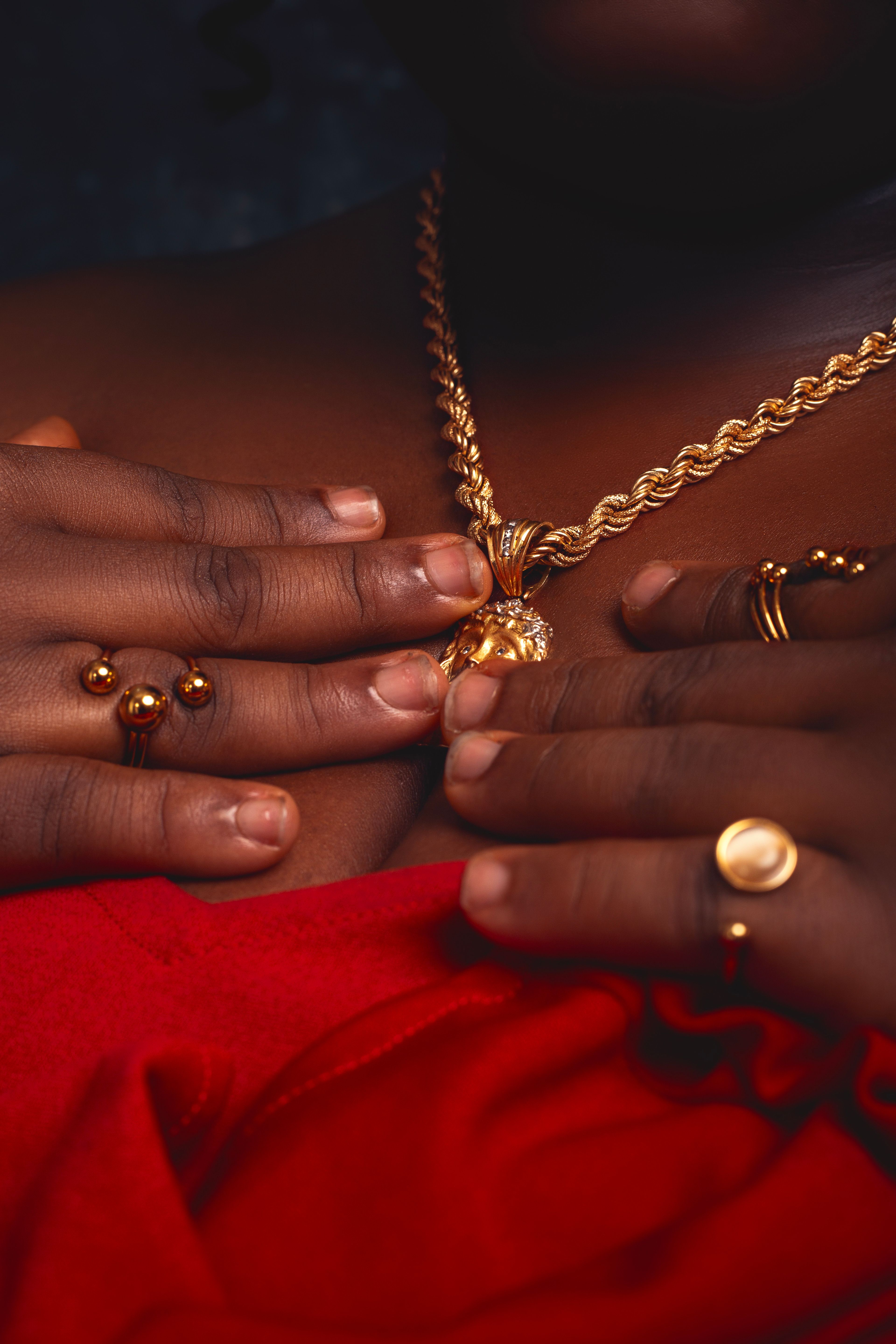 Elegant Gold Jewelry on Model's Hands in Red Dress · Free Stock Photo