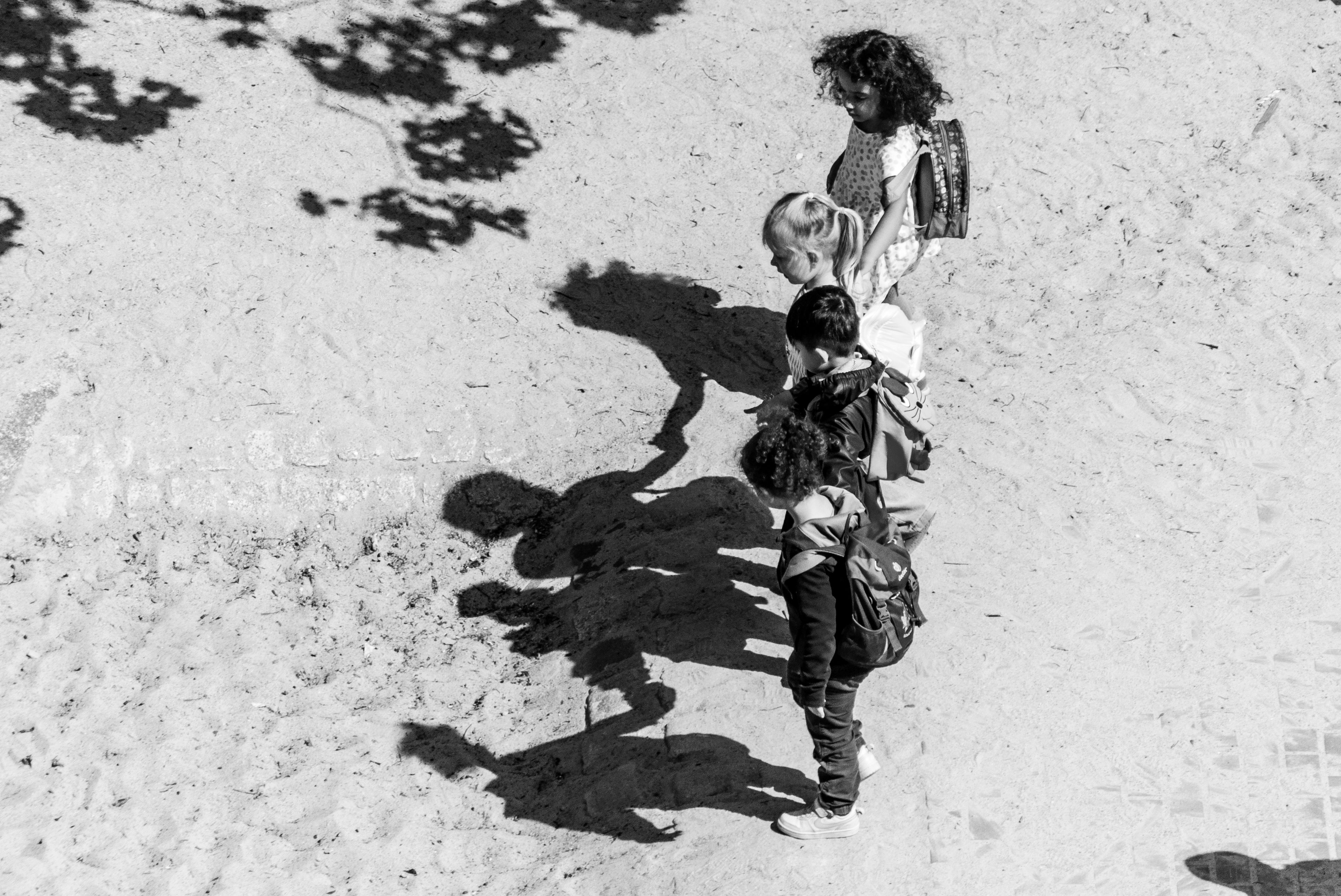 Children in Line with Shadows on Sandy Ground · Free Stock Photo