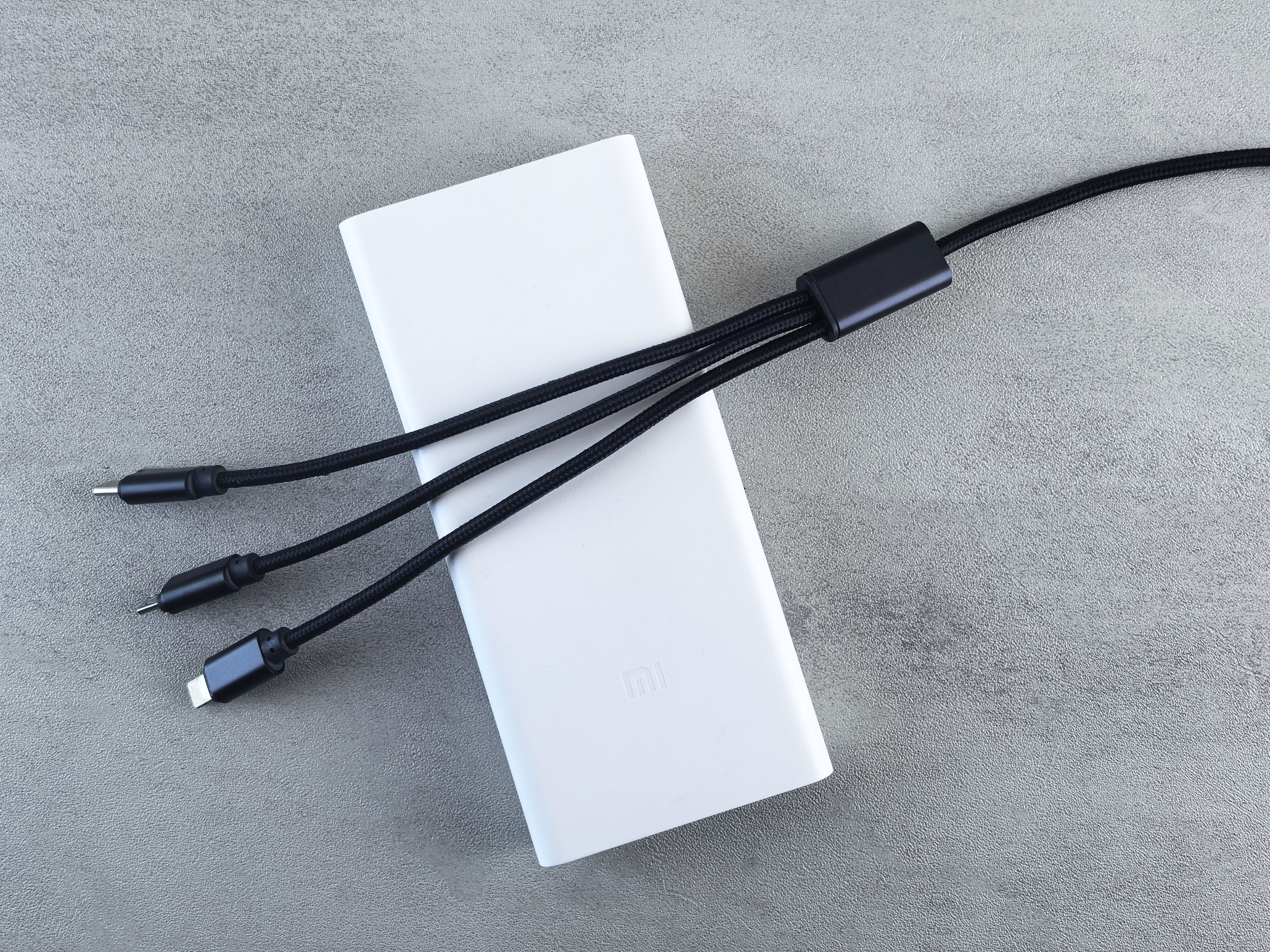 Modern Power Bank and Multi-Connector Cable on Grey Surface · Free Stock Photo