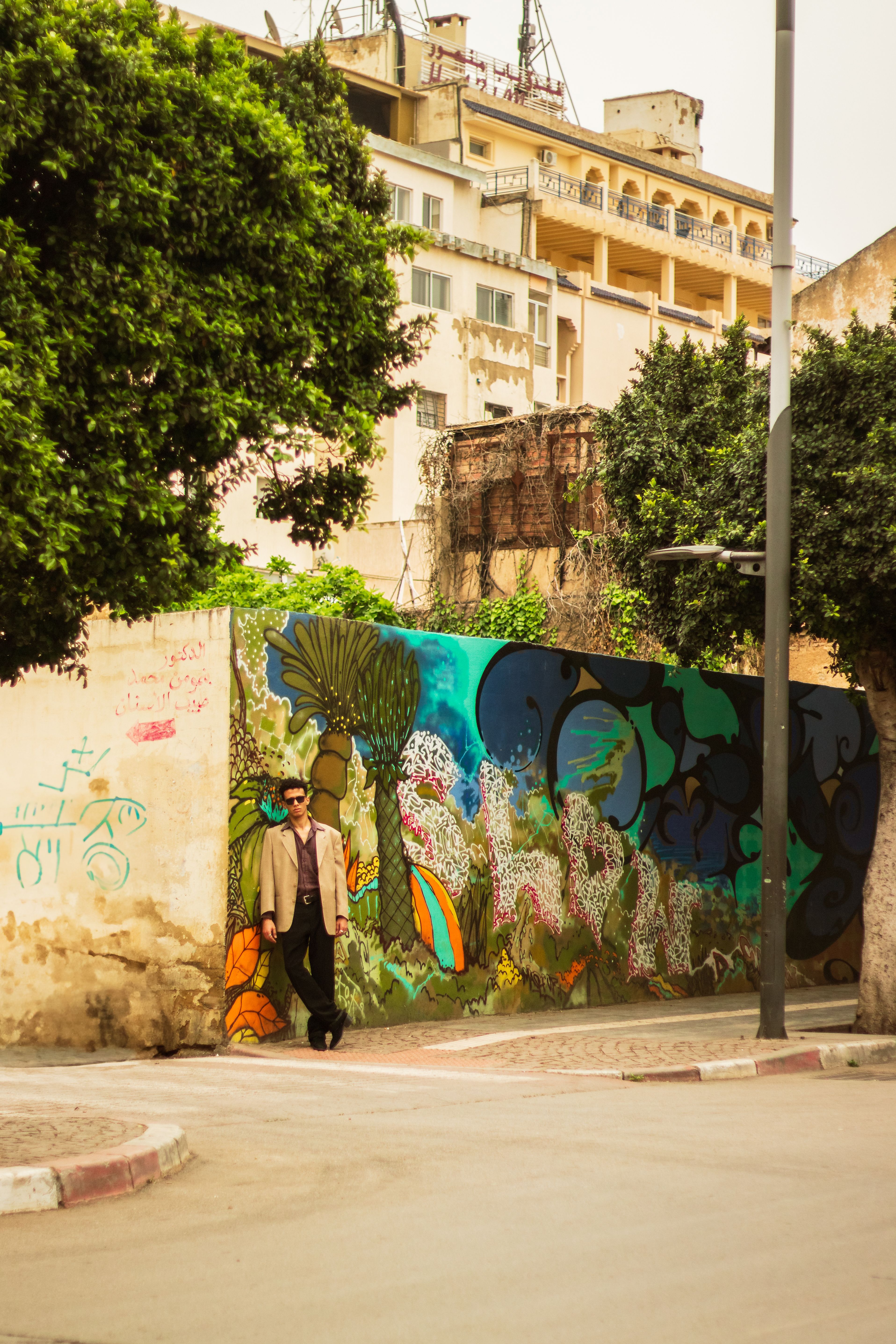 Stylish Man Walking by Moroccan Street Art · Free Stock Photo