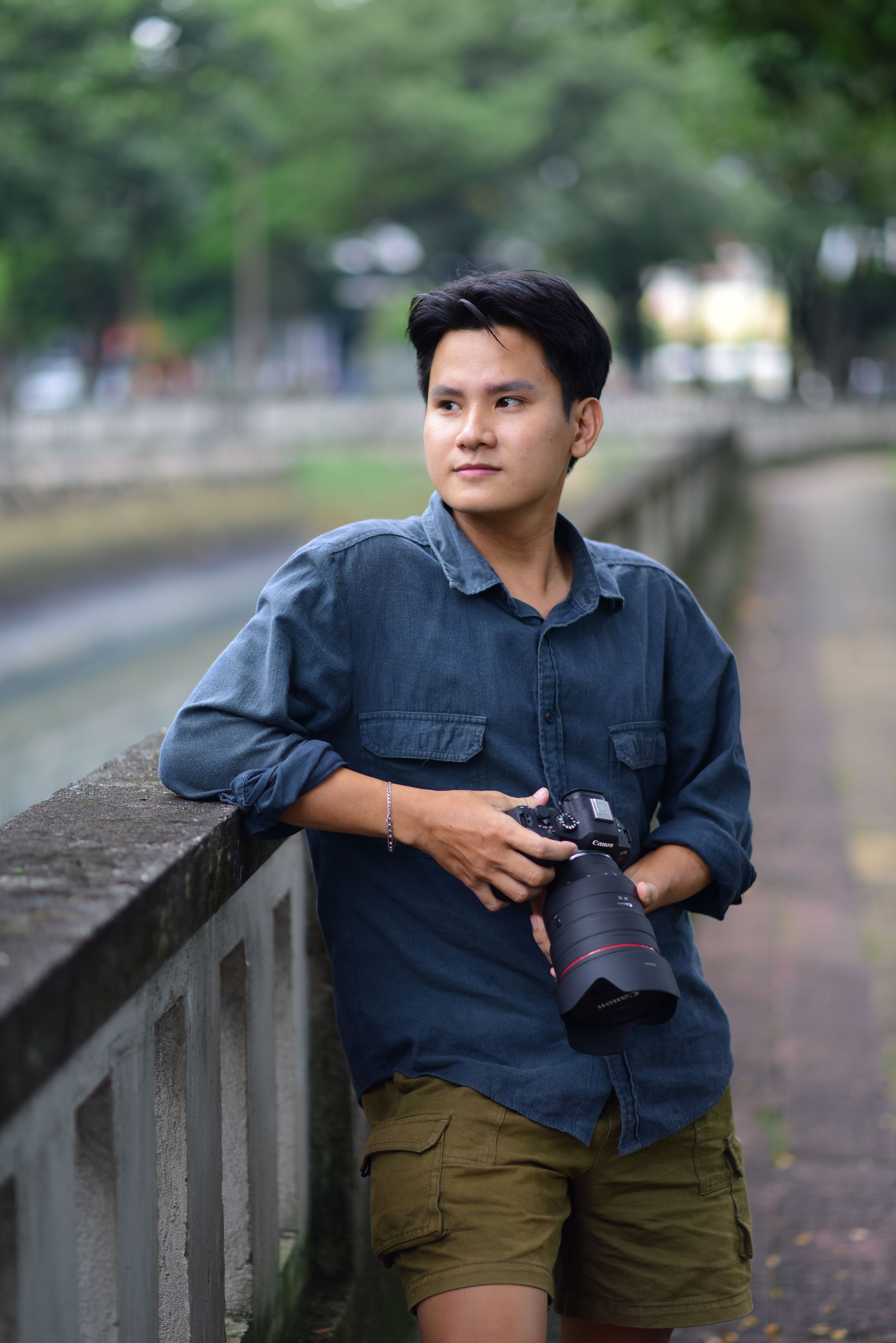 Young Photographer Posing with Camera Outdoors · Free Stock Photo