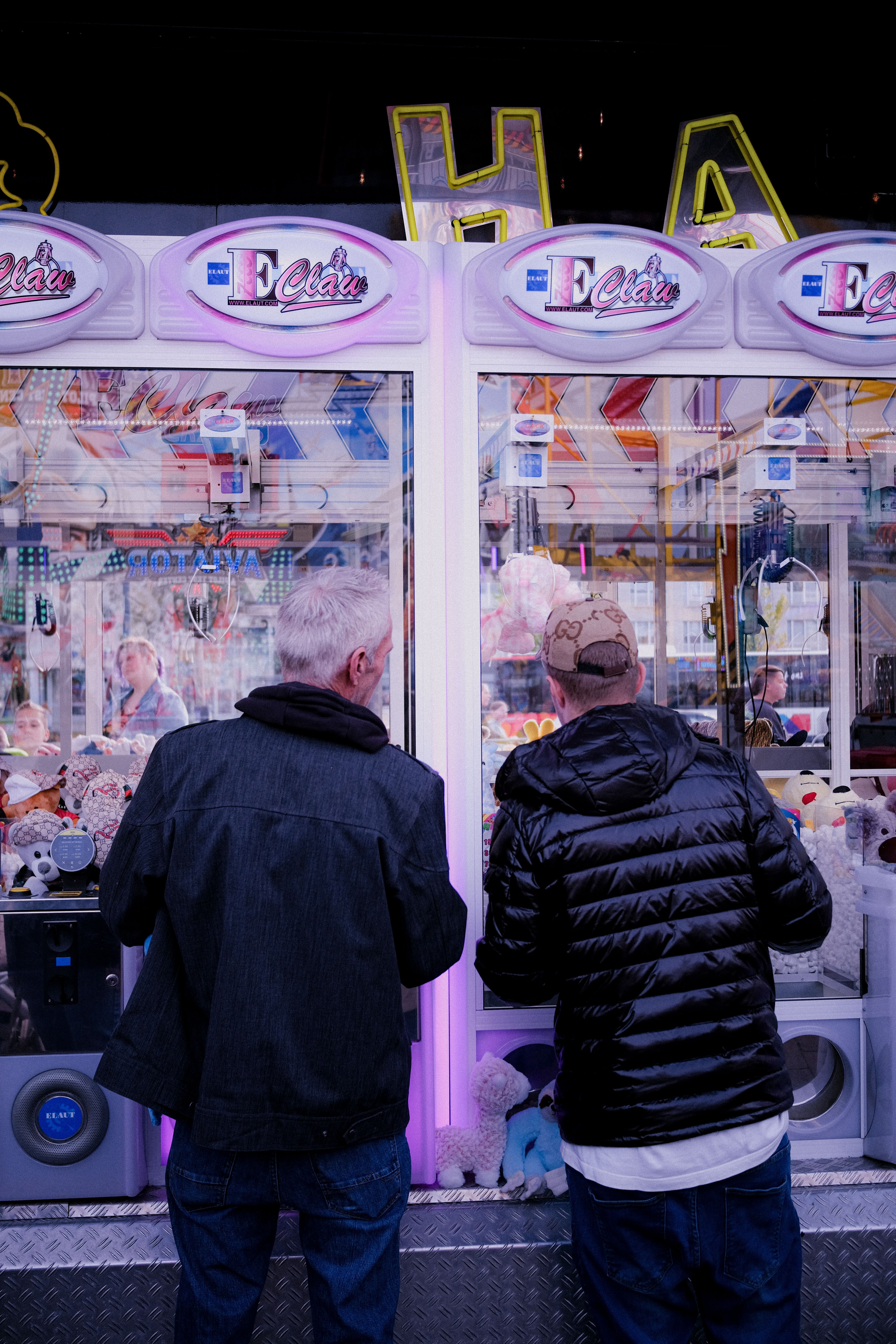 Men Enjoying Arcade Claw Machine Fun · Free Stock Photo