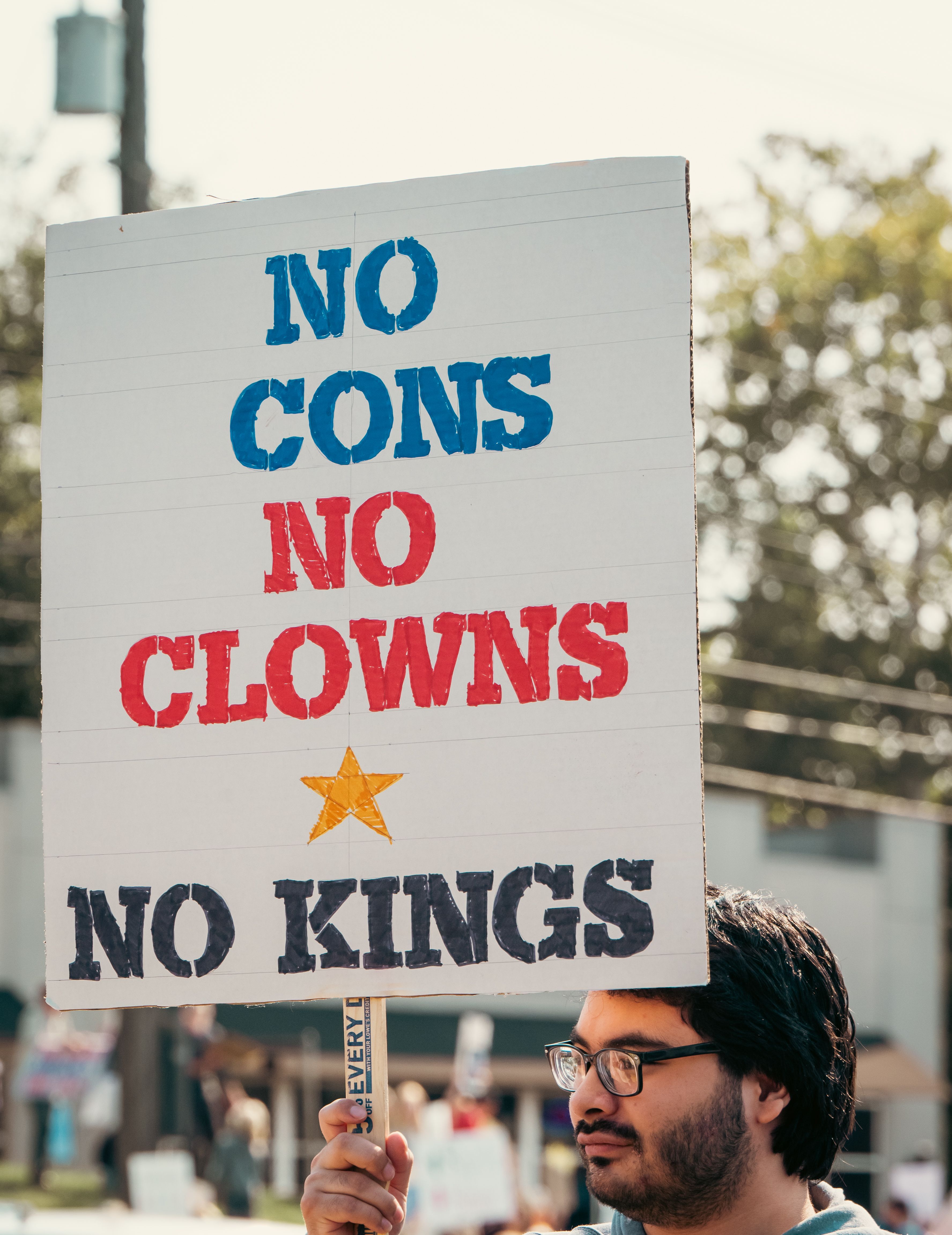 Protester Holding Sign Against Political Figures · Free Stock Photo