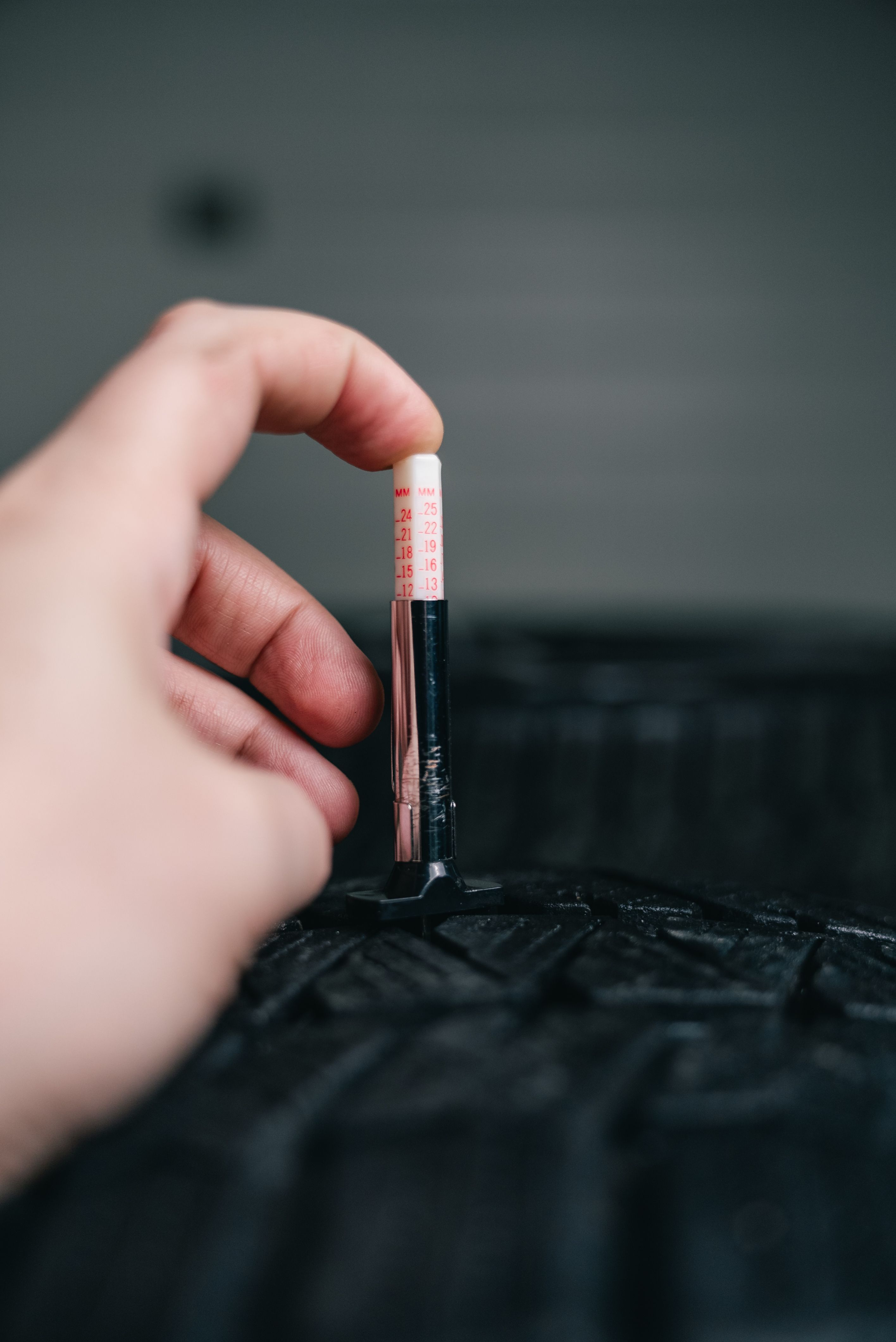 Person Measuring Tire Tread Depth with Gauge · Free Stock Photo