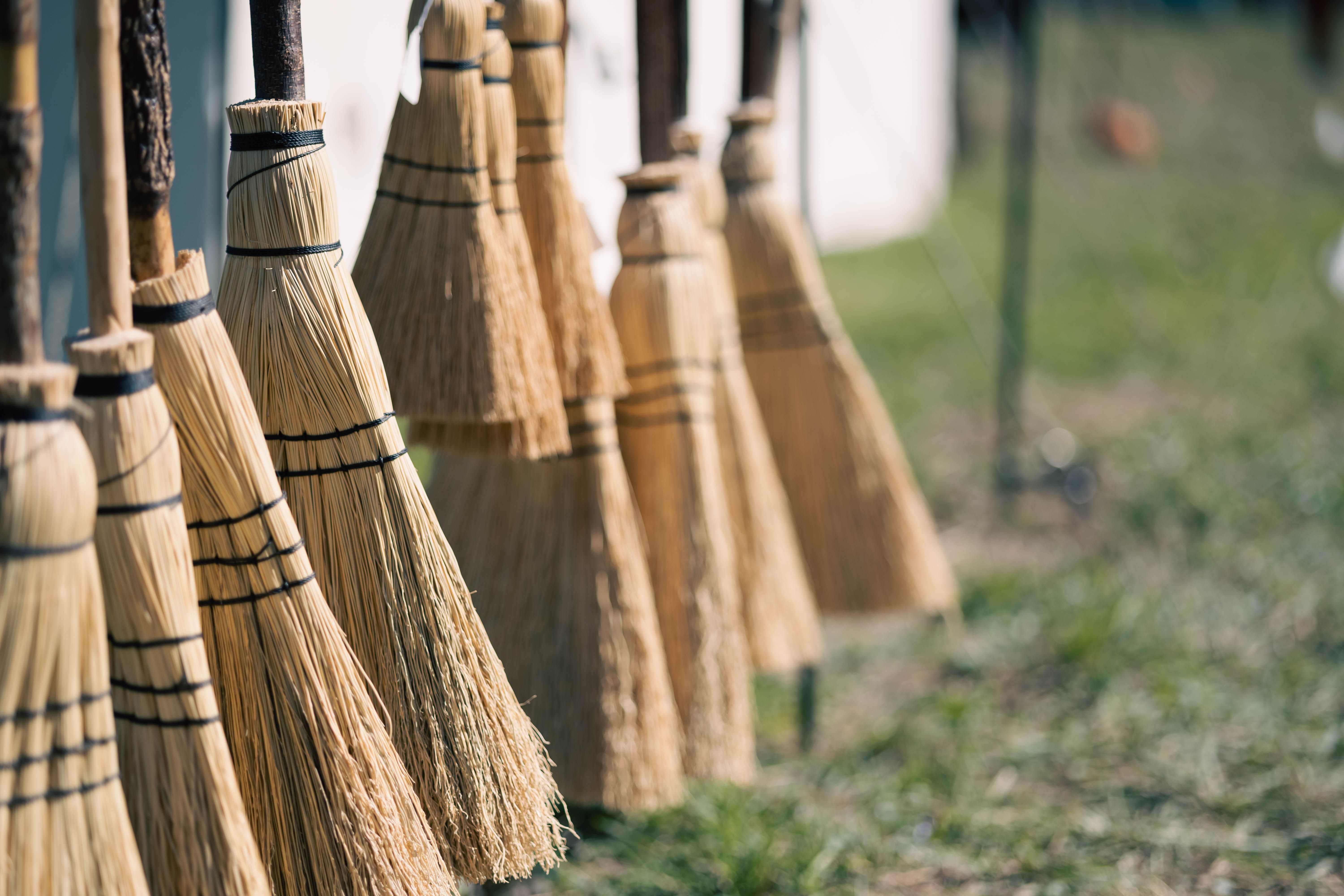 Traditional Straw Brooms Hanging Outdoors · Free Stock Photo