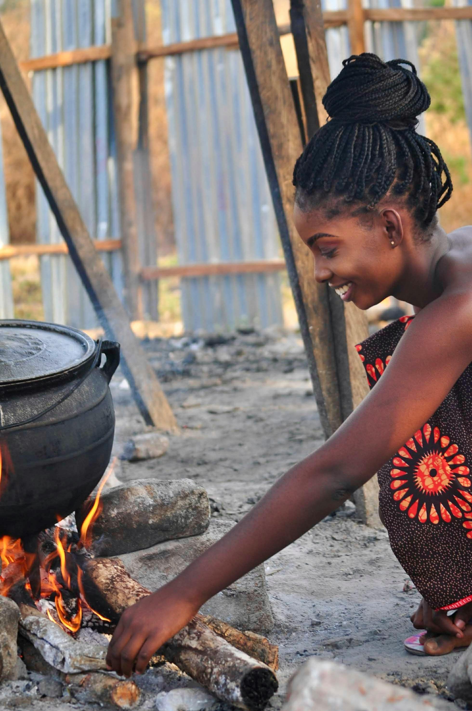 Nigerian Woman Cooking with Traditional Pot Outdoors · Free Stock Photo