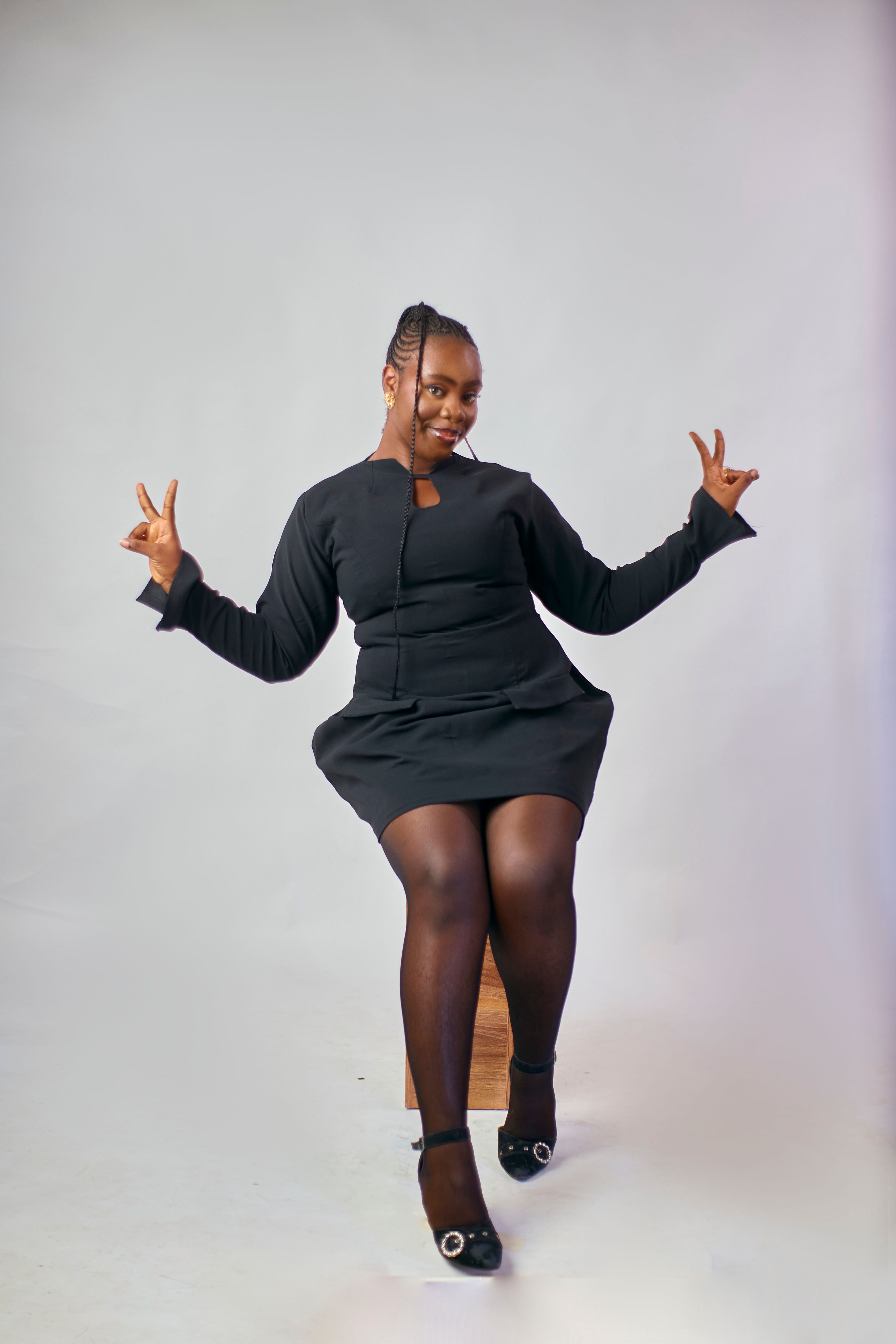 Portrait of a Woman in Black Dress Making Peace Sign · Free Stock Photo