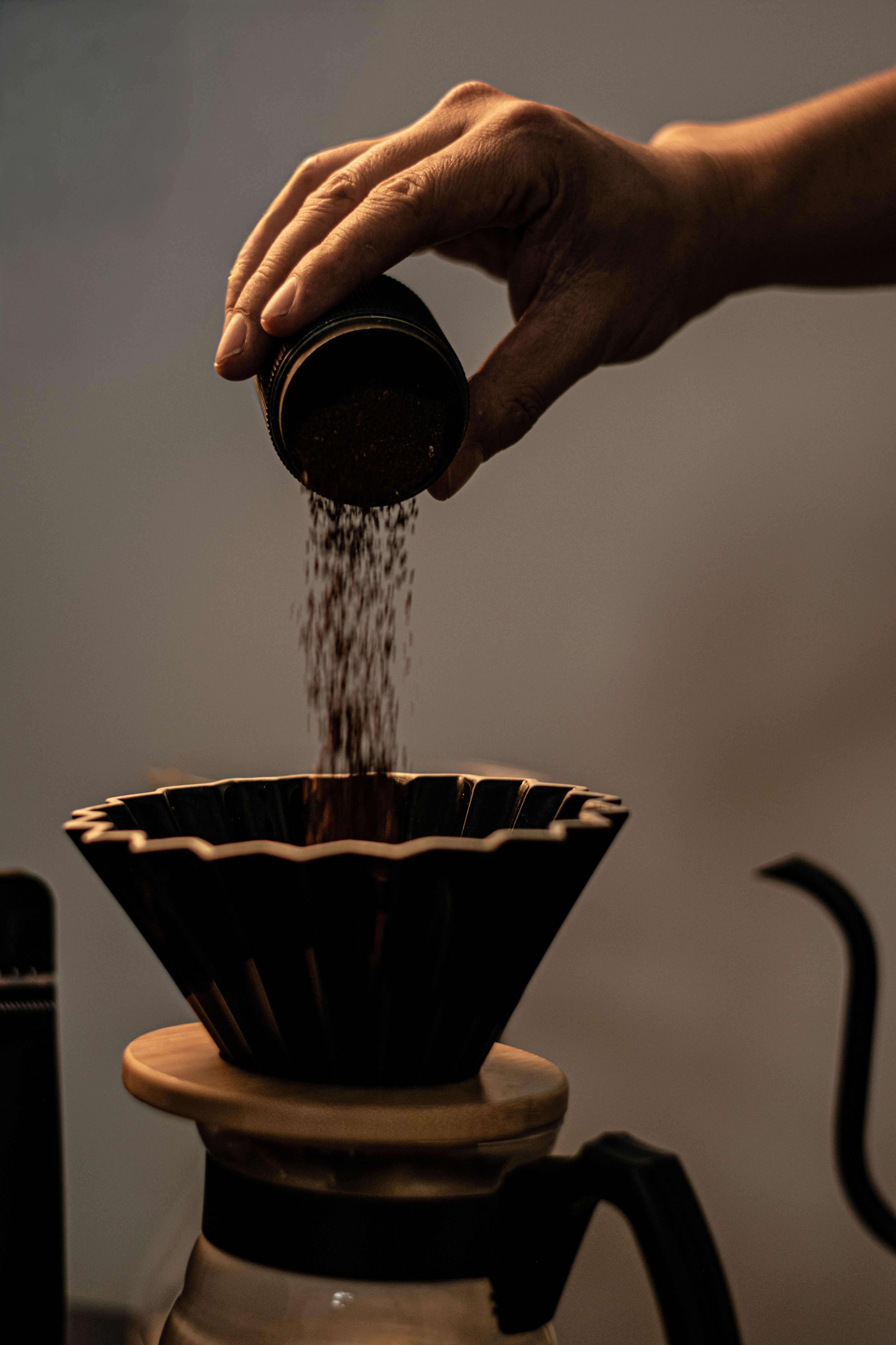 Pouring Coffee Grounds Into a Filter · Free Stock Photo