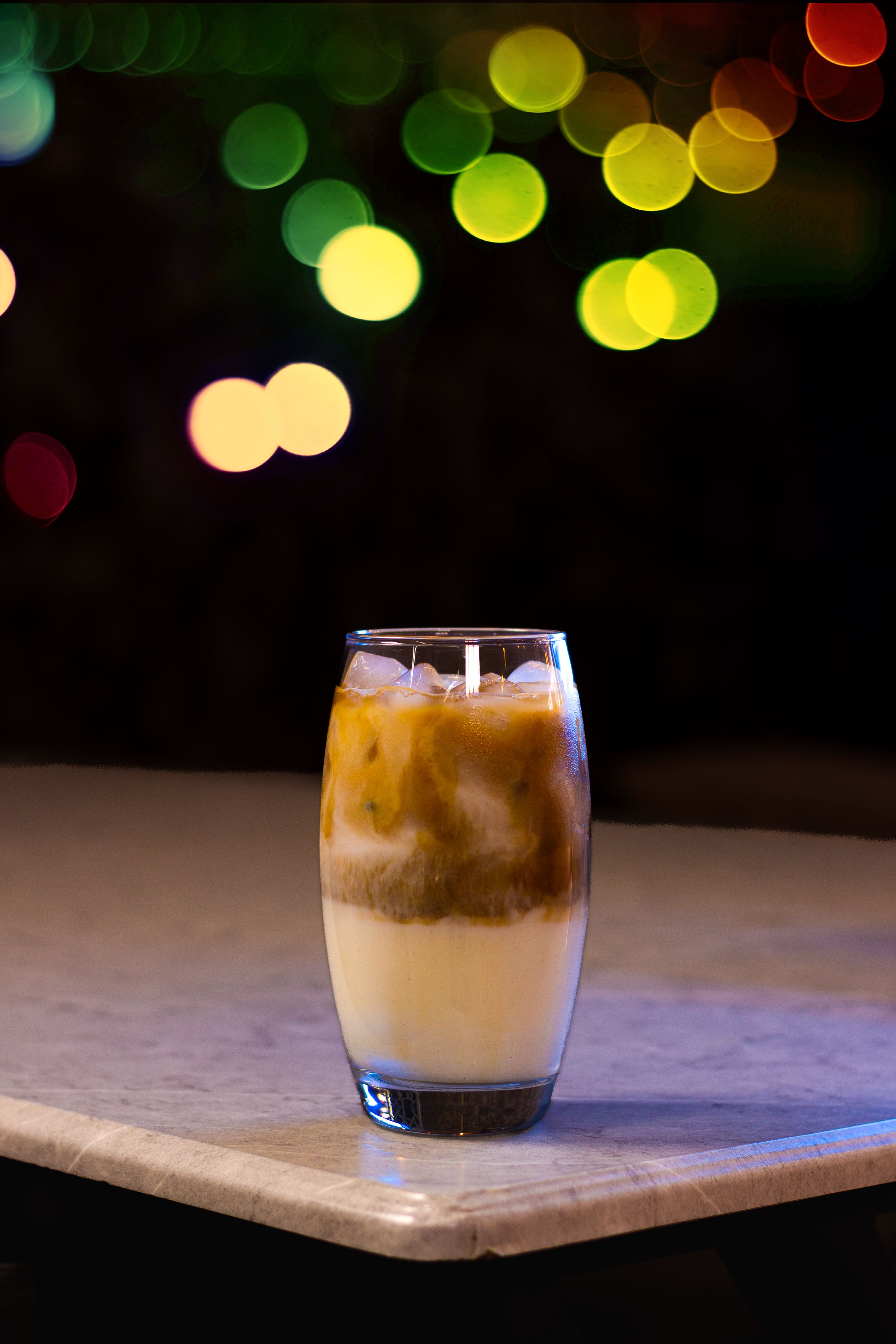 Iced Latte on Marble Table in Colorful Cafe · Free Stock Photo