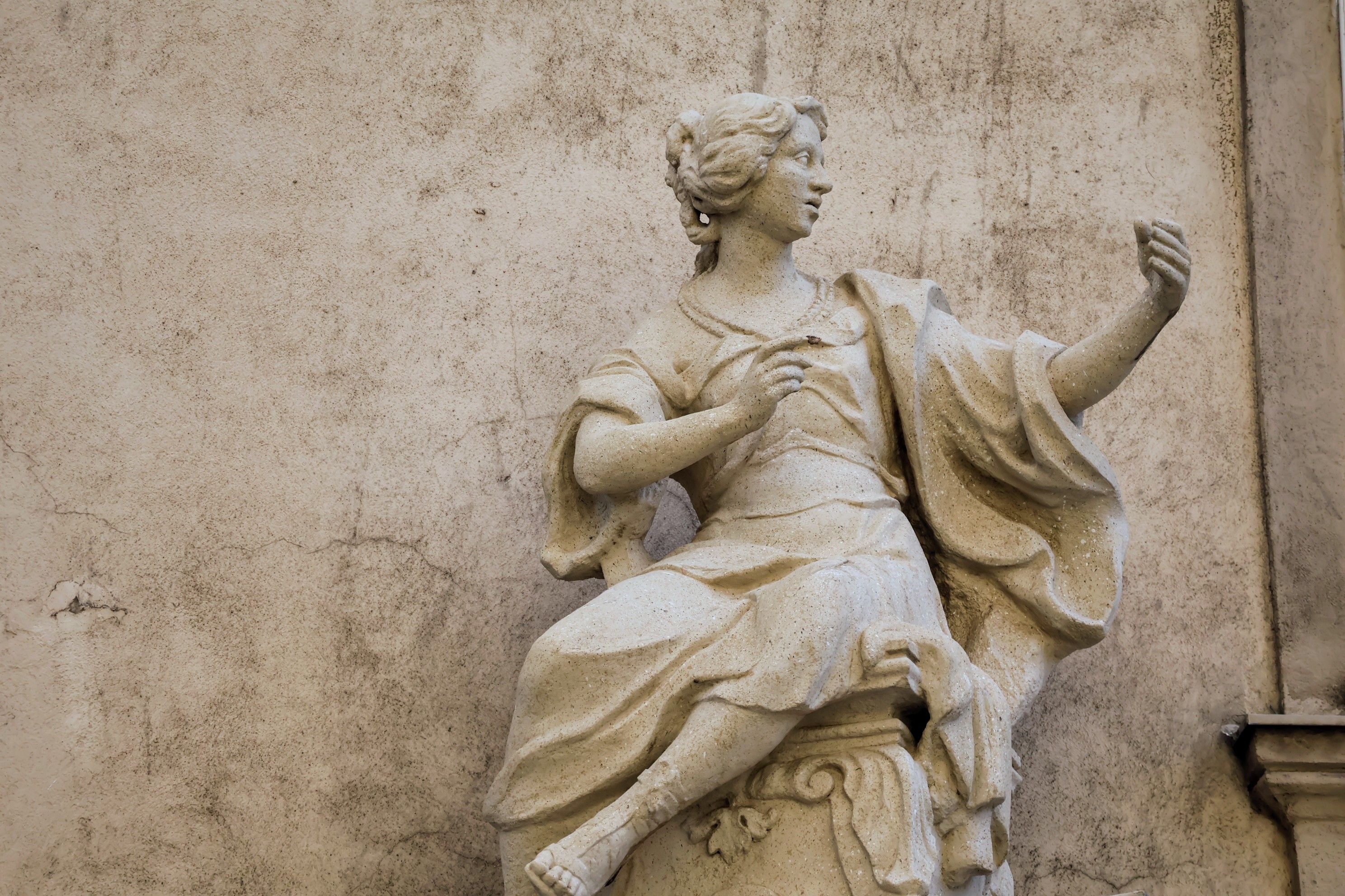 Intricate Stone Statue against Weathered Wall · Free Stock Photo