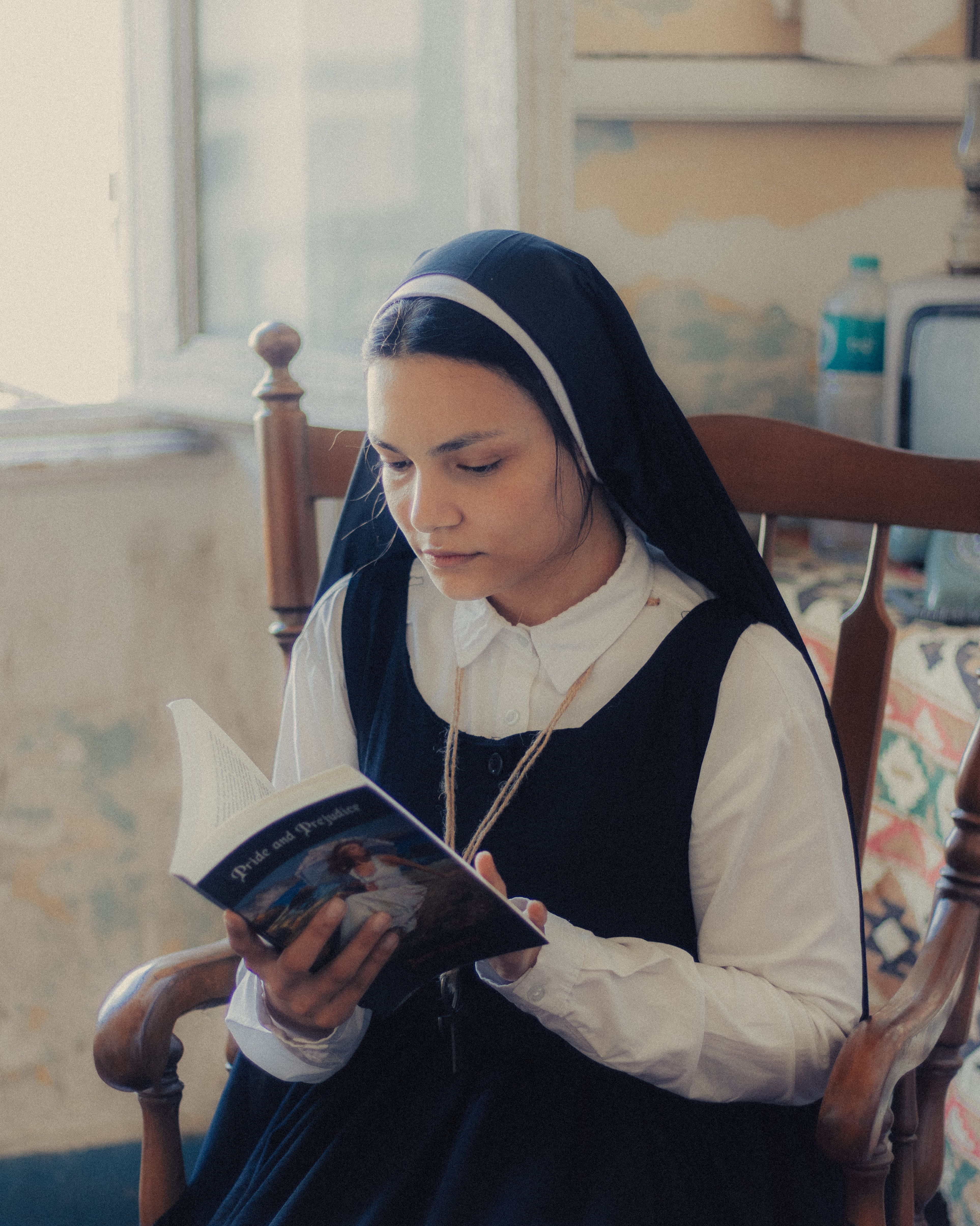 Nun Reading a Book by Sunlit Window in Alexandria · Free Stock Photo
