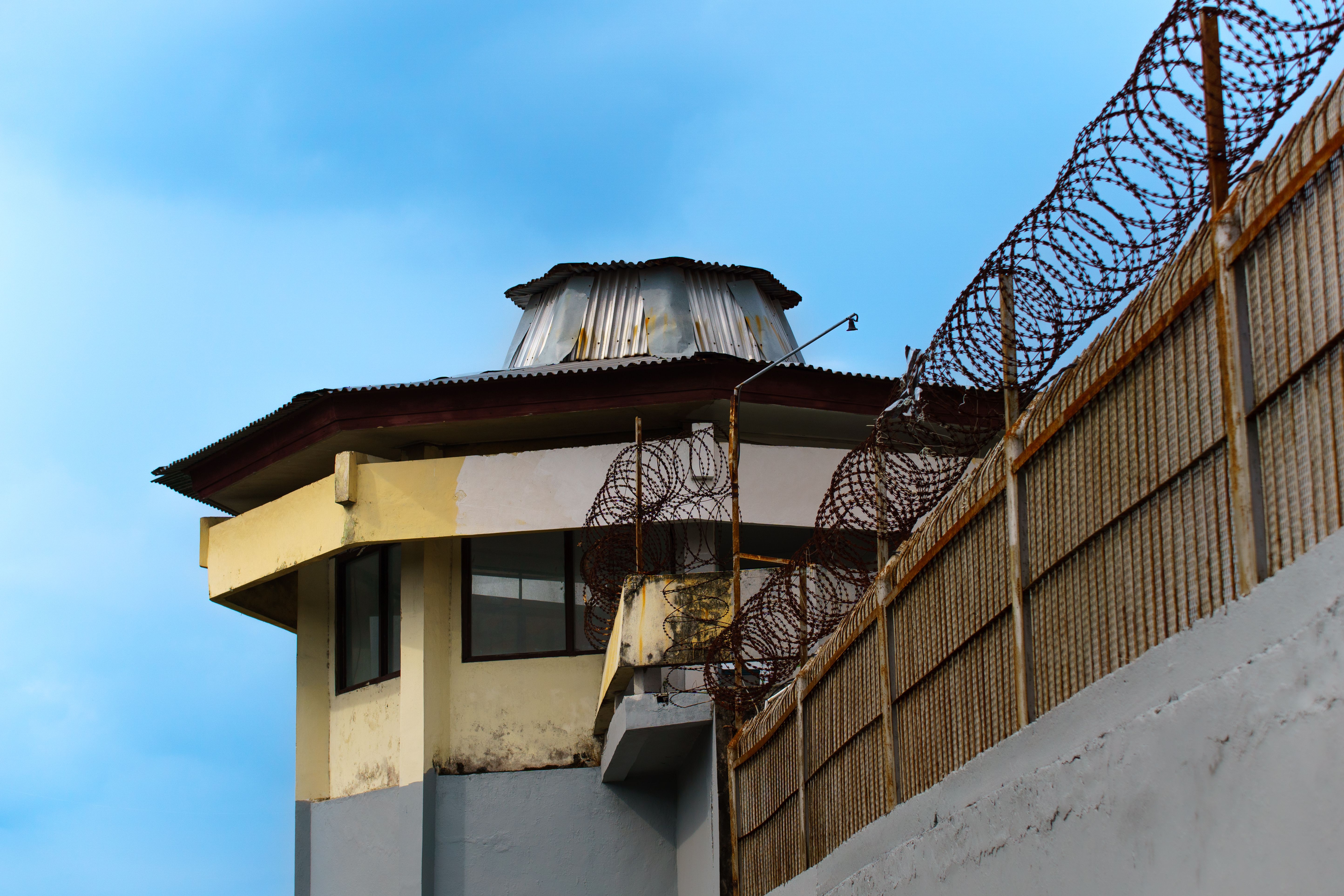 Prison Watchtower with Barbed Wire and Blue Sky · Free Stock Photo
