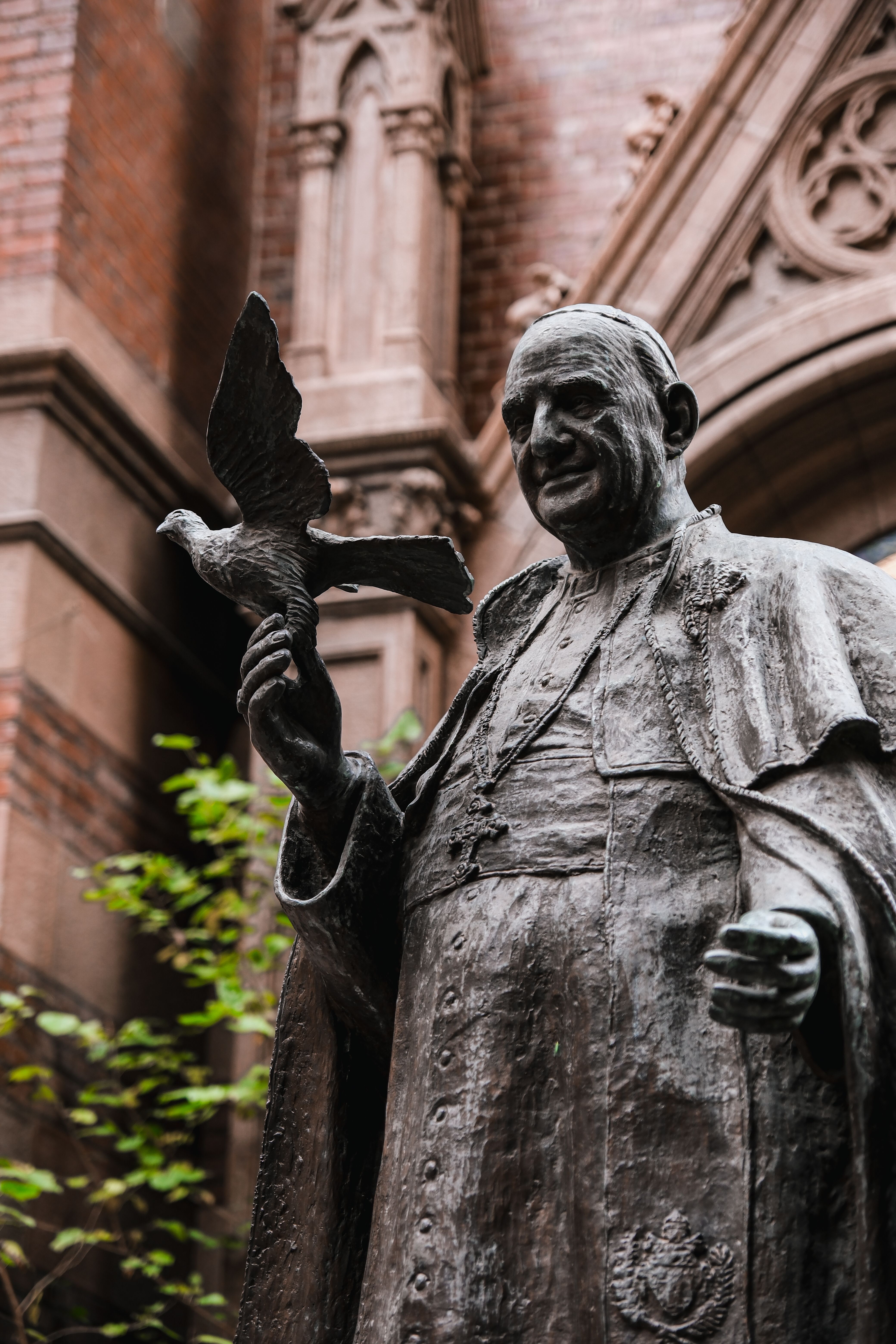Bronze Statue Holding a Dove Outside Historic Building · Free Stock Photo