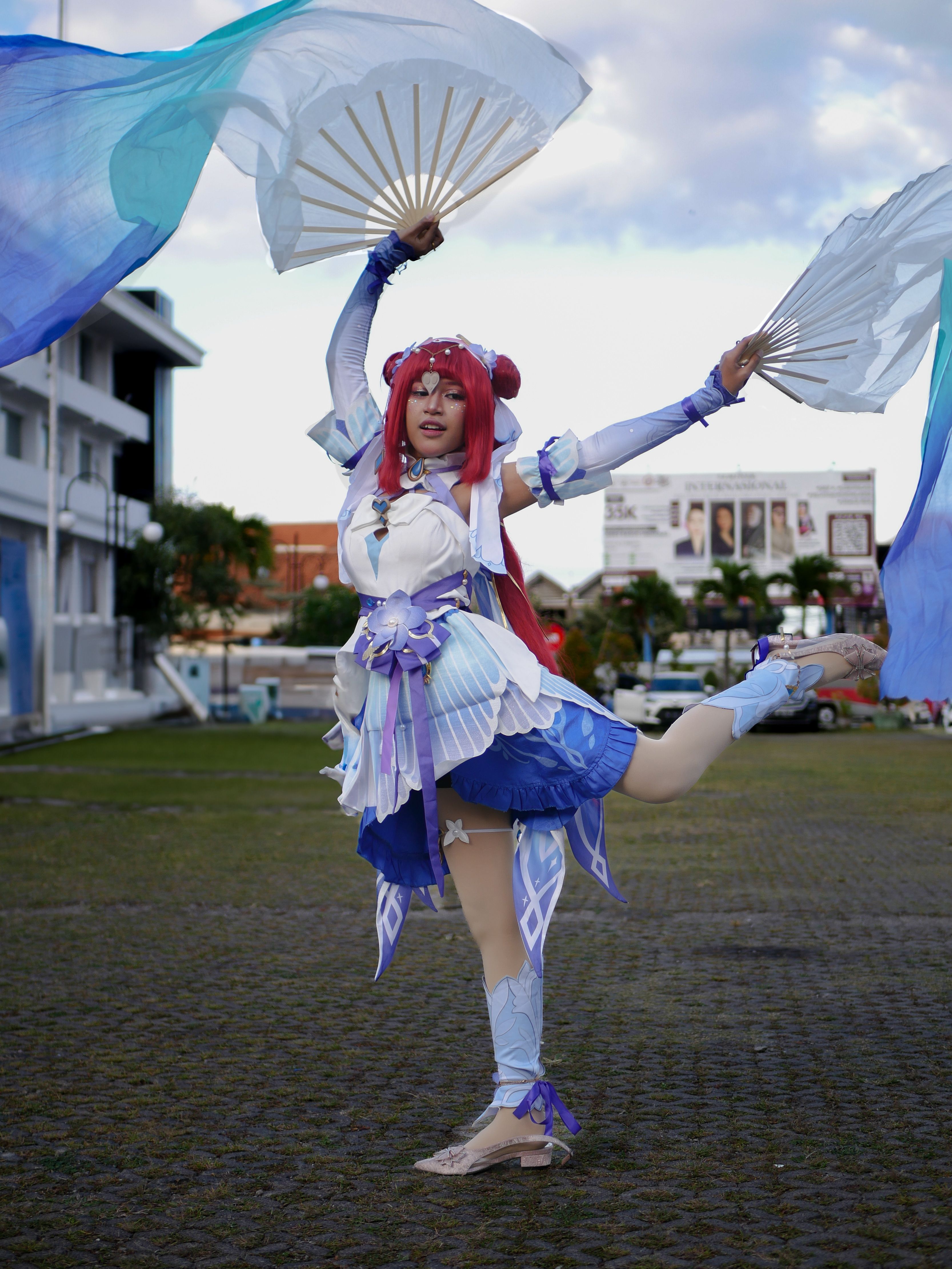 Vibrant Outdoor Cosplay Performance with Fan Props · Free Stock Photo