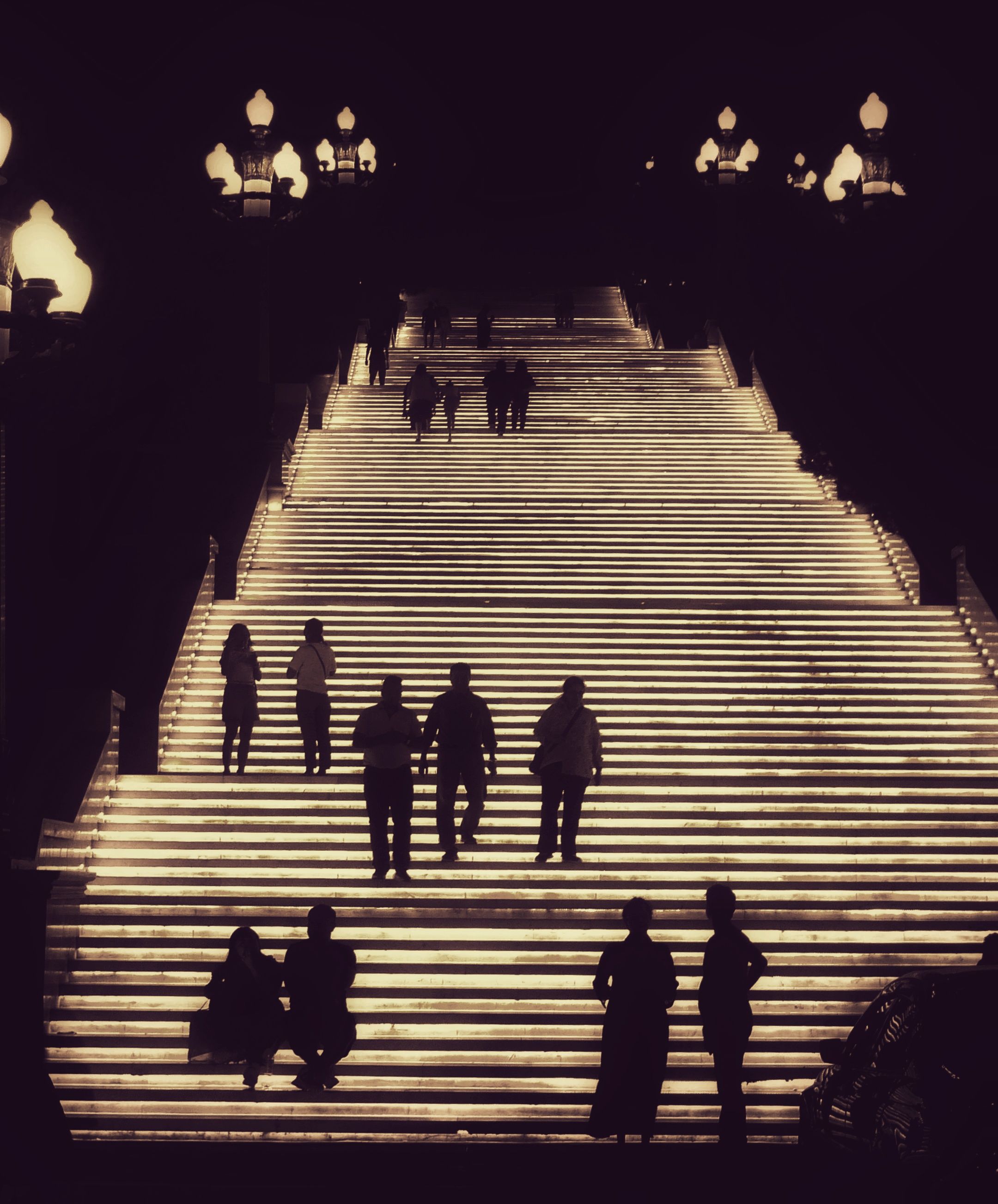 Silhouetted Figures on Illuminated Night Stairs · Free Stock Photo