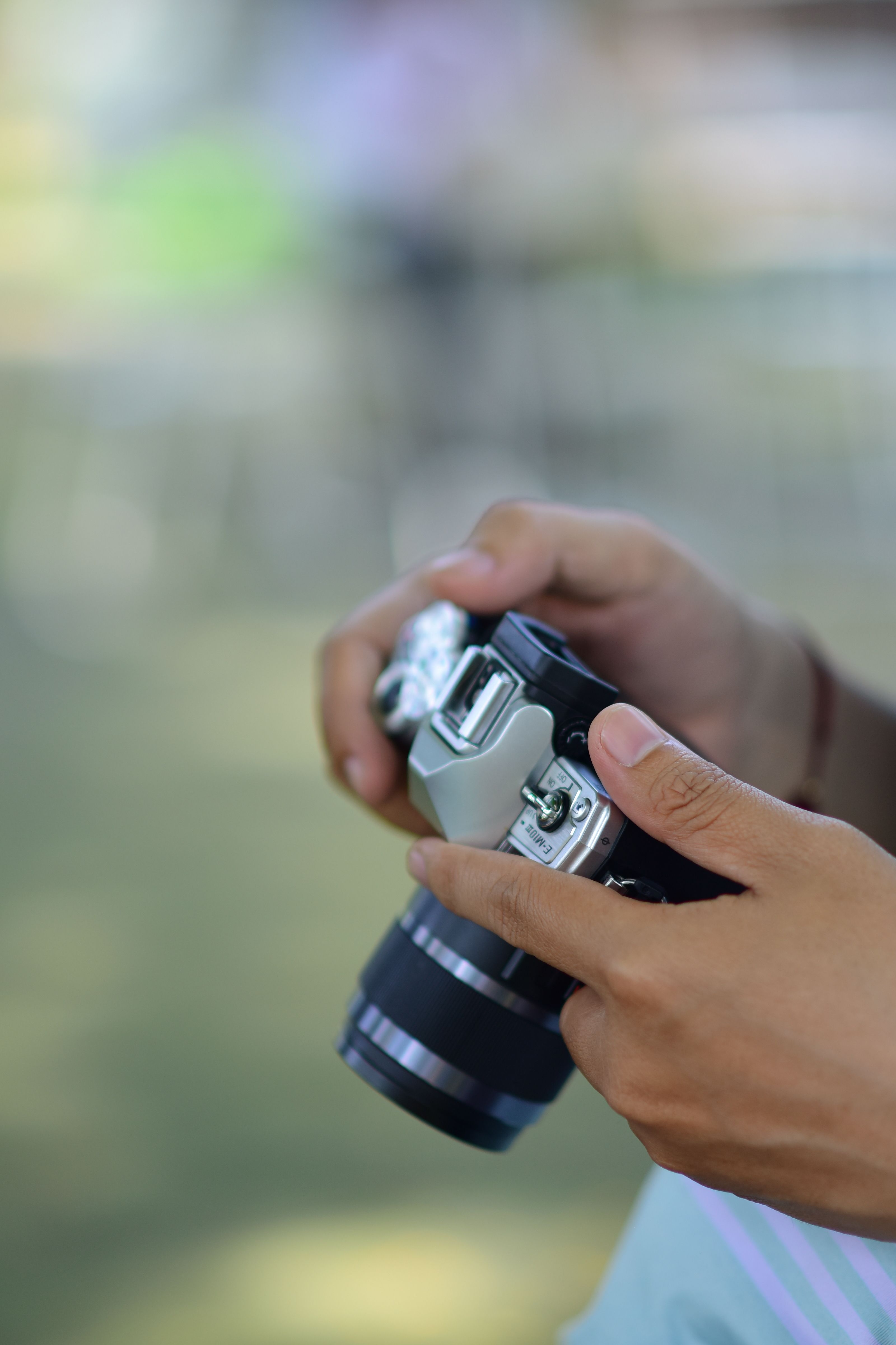 Close-up of Hands Holding a Modern Camera Outdoors · Free Stock Photo