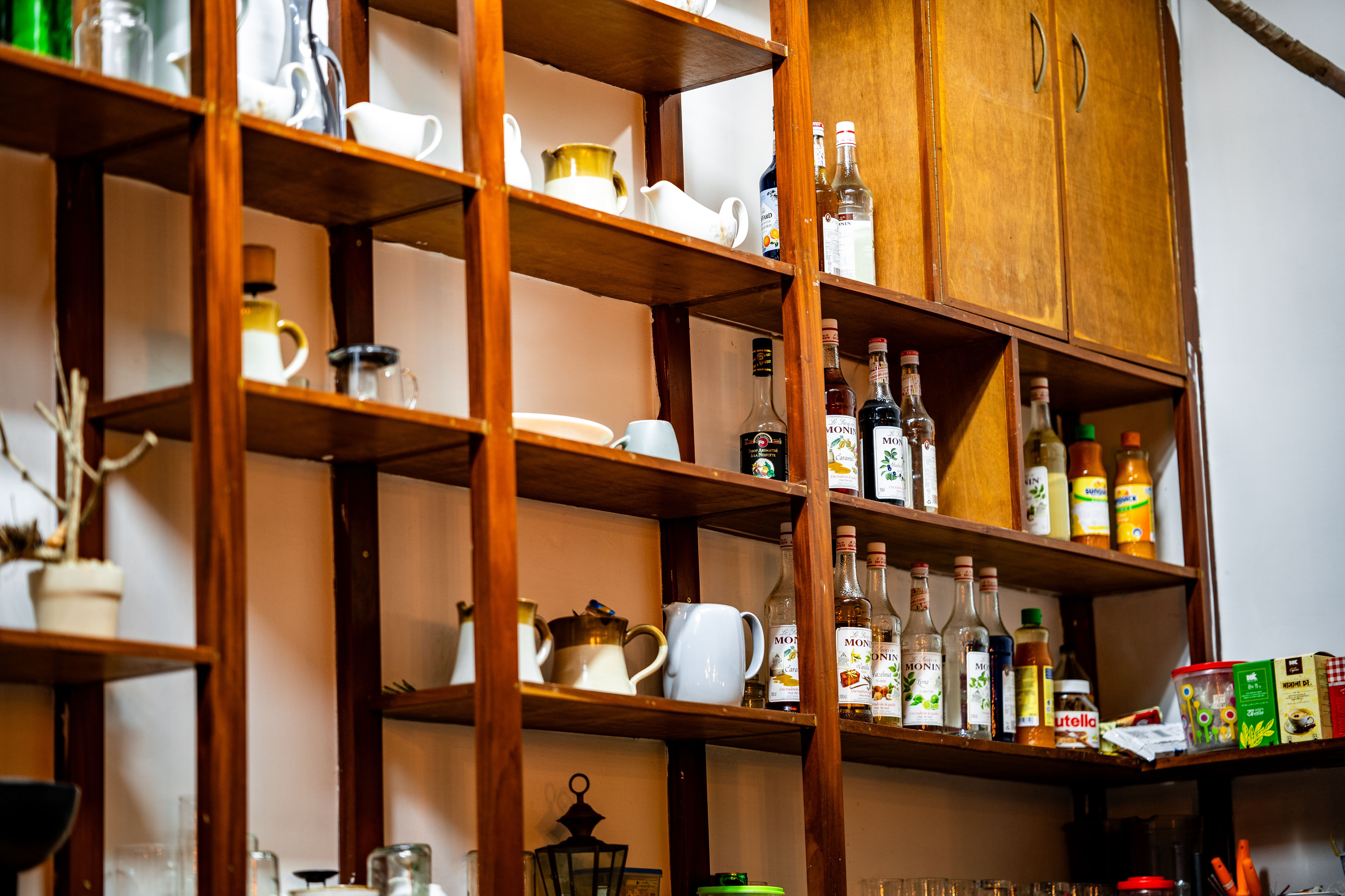 Organized Café Shelving with Bottles and Mugs · Free Stock Photo