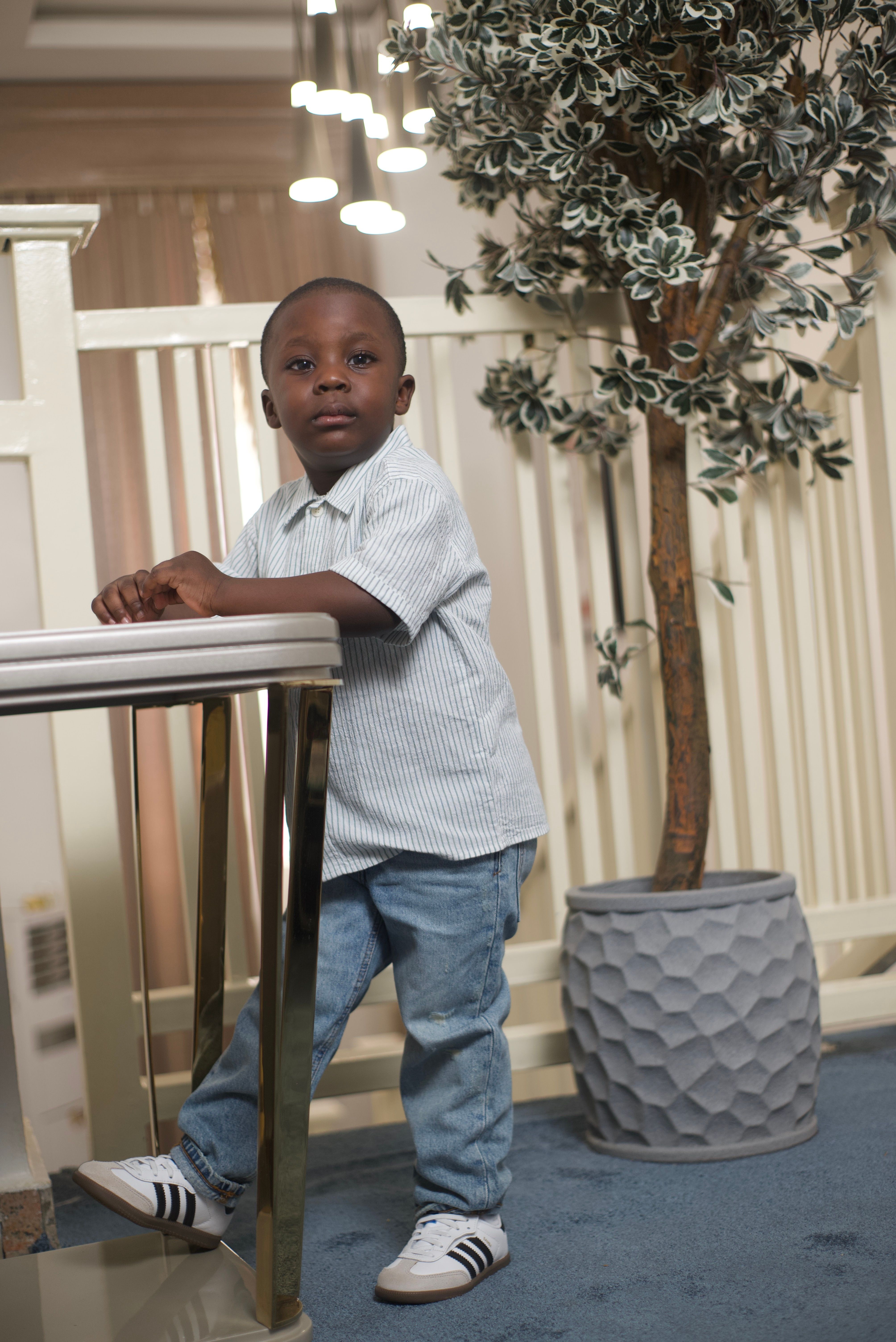 Adorable Child Leaning on a Table in Modern Home · Free Stock Photo